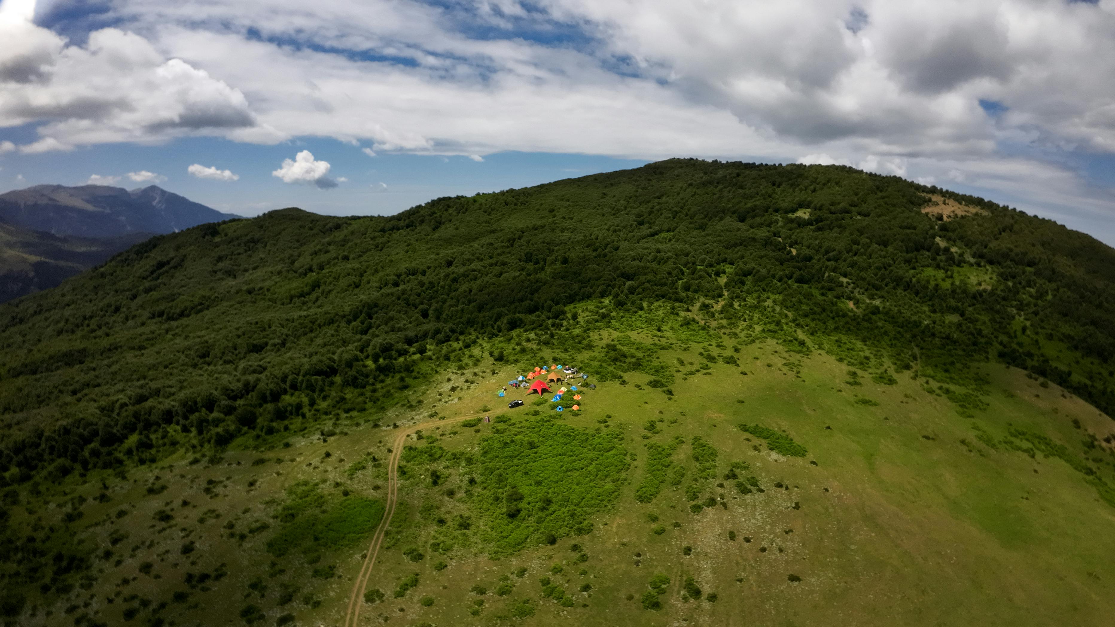 Aerial View of Mountain Camp in Lush Green Hills · Free Stock Photo