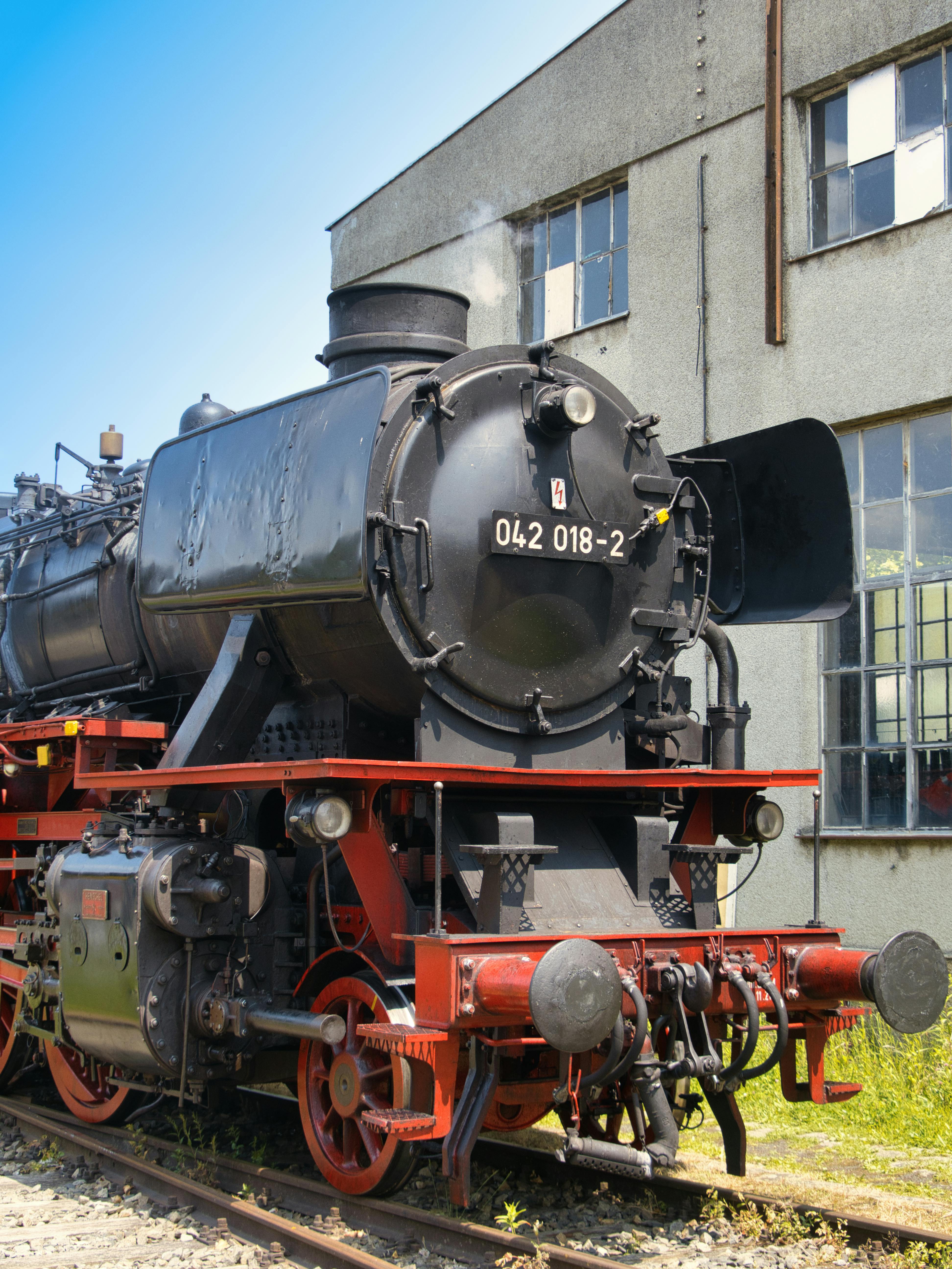 Historic Steam Locomotive in Industrial Setting · Free Stock Photo