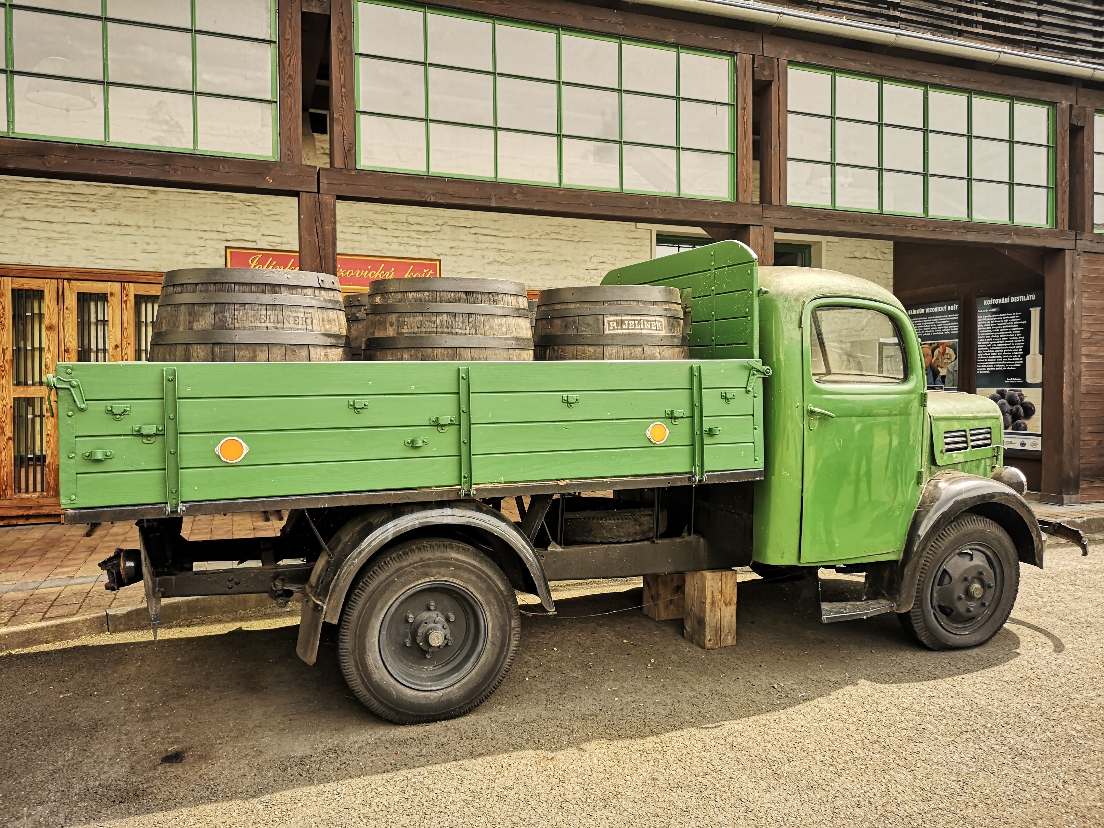 Vintage Green Truck with Wooden Barrel Load · Free Stock Photo