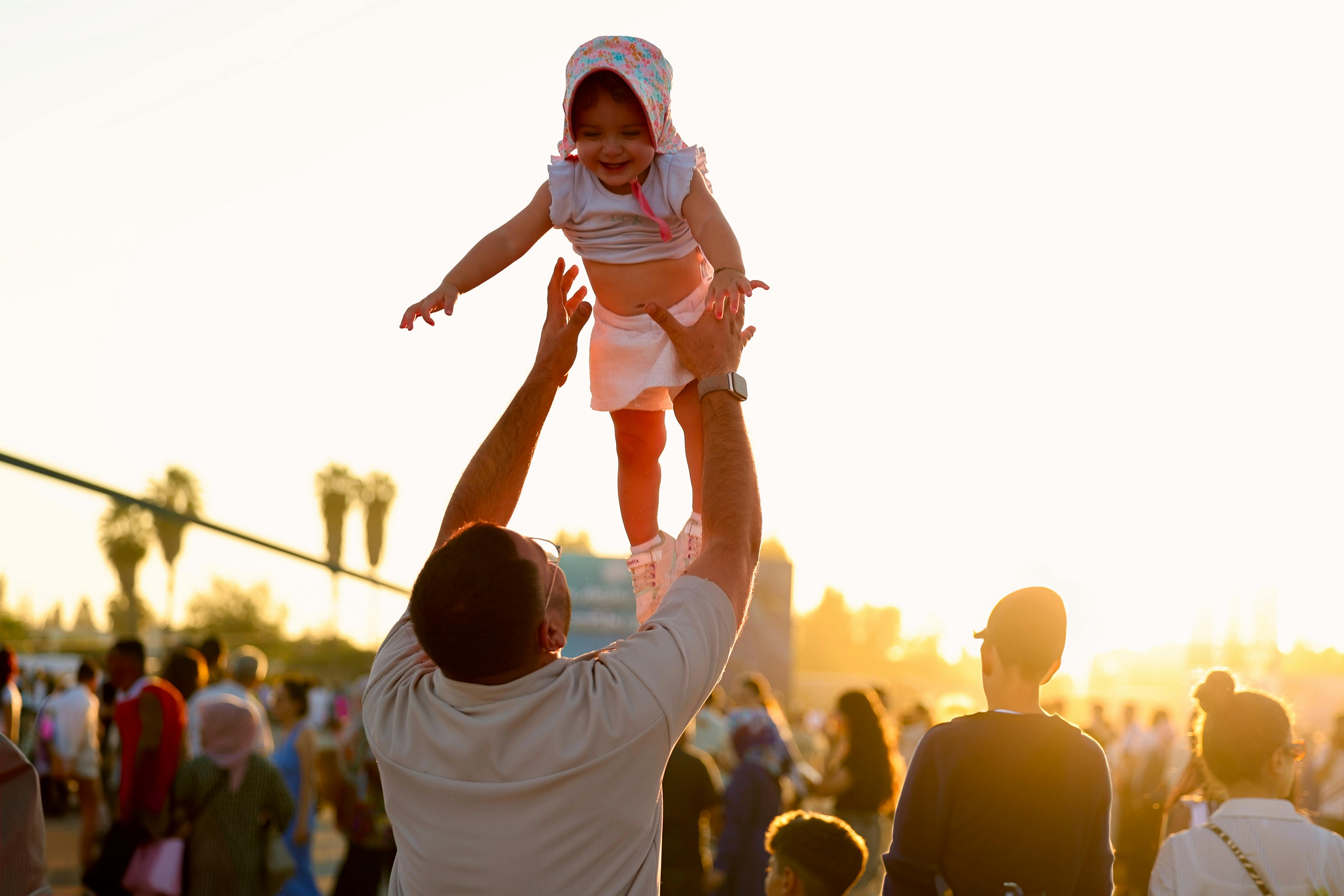 Father Lifting Daughter at Outdoor Festival · Free Stock Photo