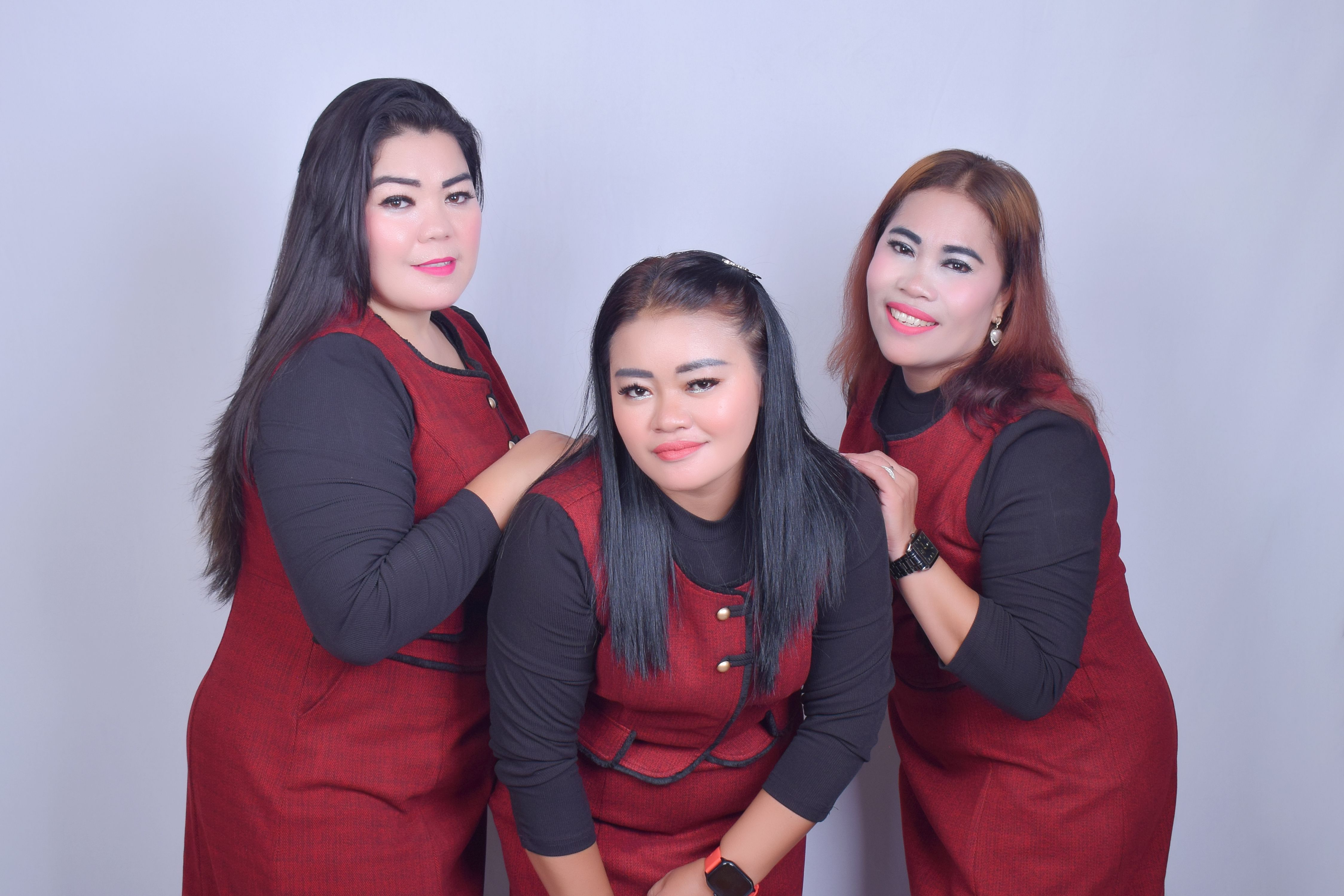 Three Women in Red Uniforms Posing Together · Free Stock Photo