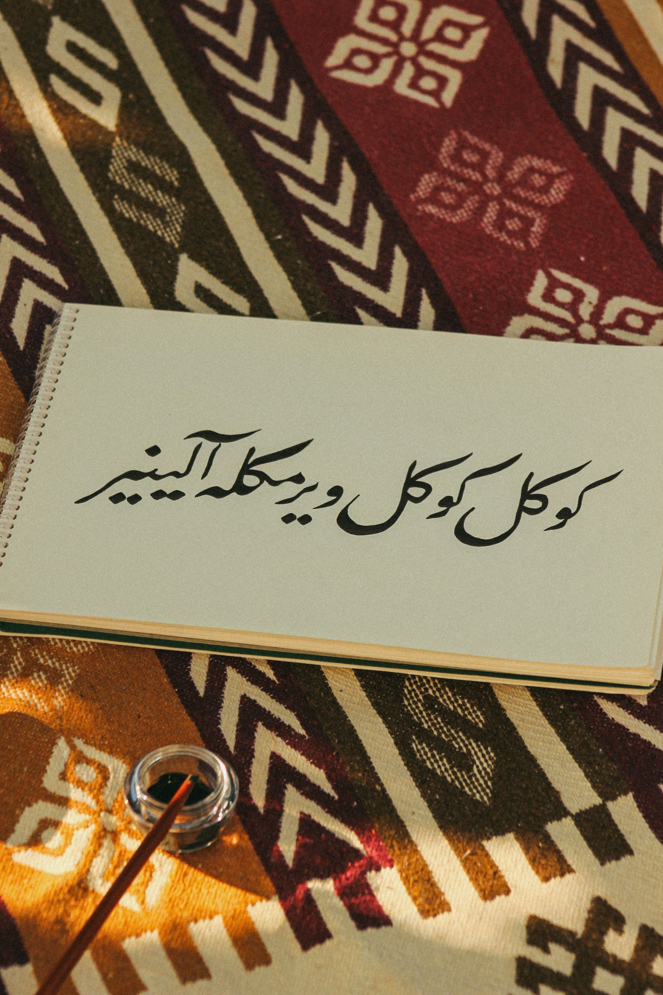 Persian Calligraphy on Patterned Rug · Free Stock Photo