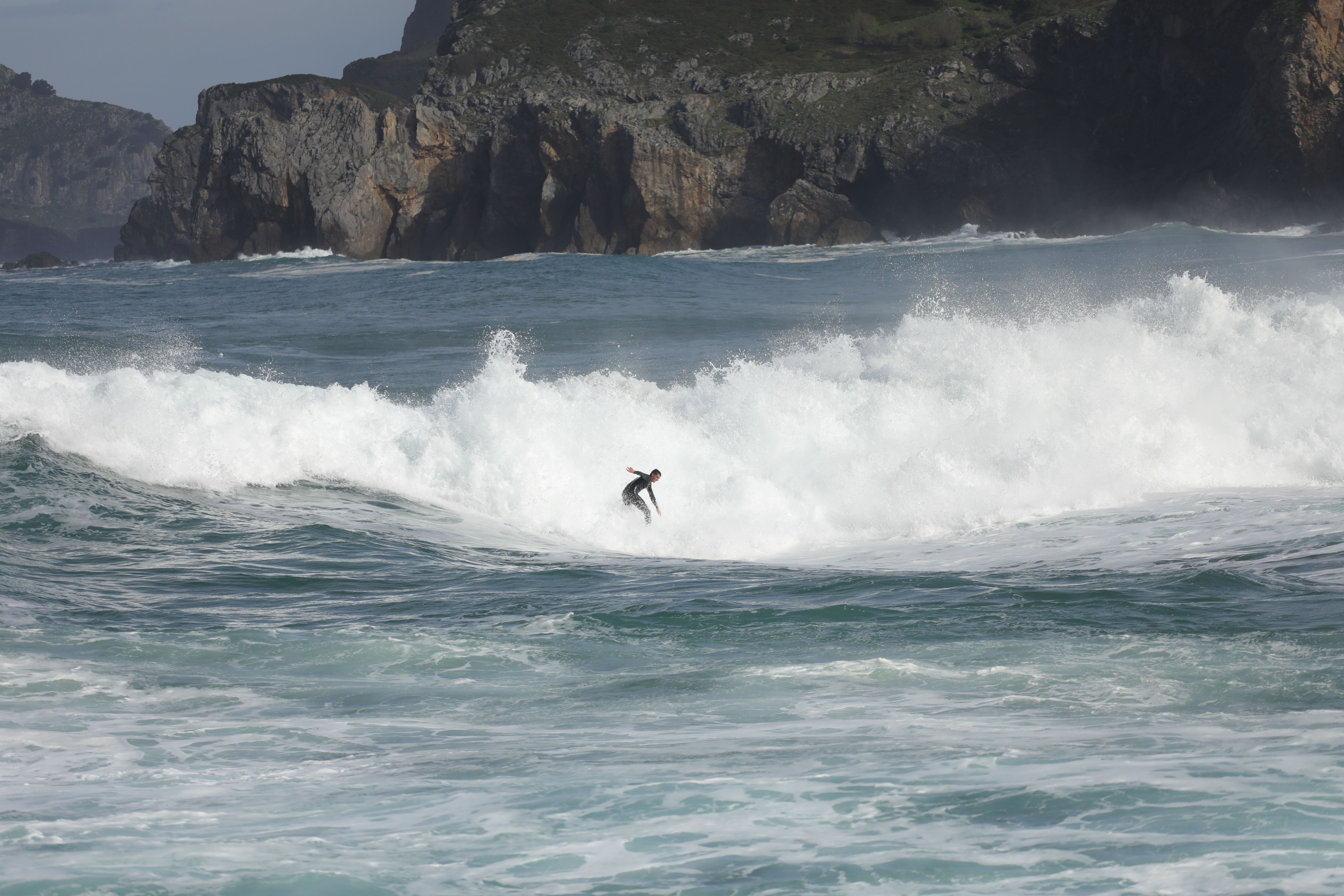 Dynamic Surfing Adventure on Rugged Coastline · Free Stock Photo