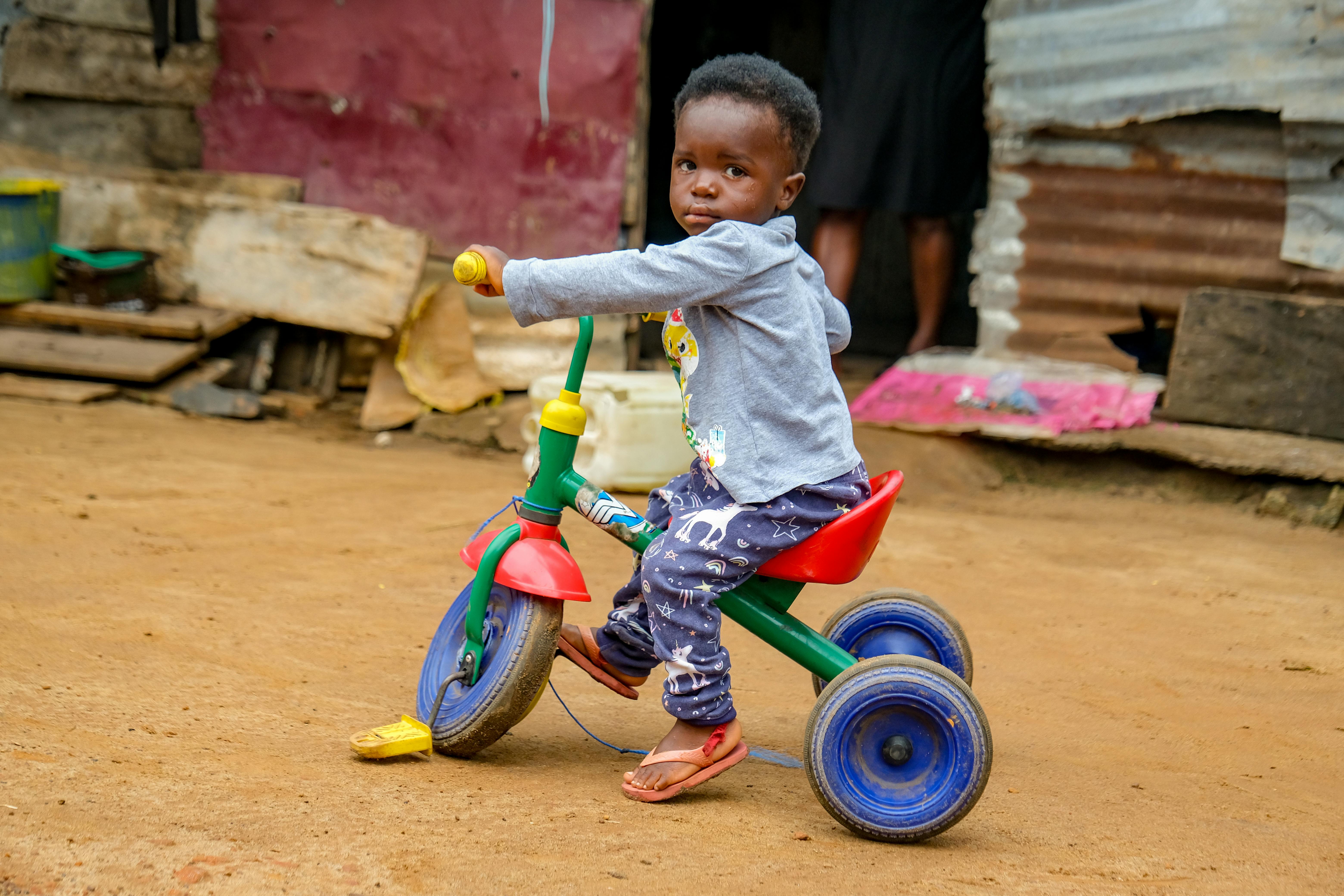 Child Riding Tricycle Outdoors in Monrovia · Free Stock Photo