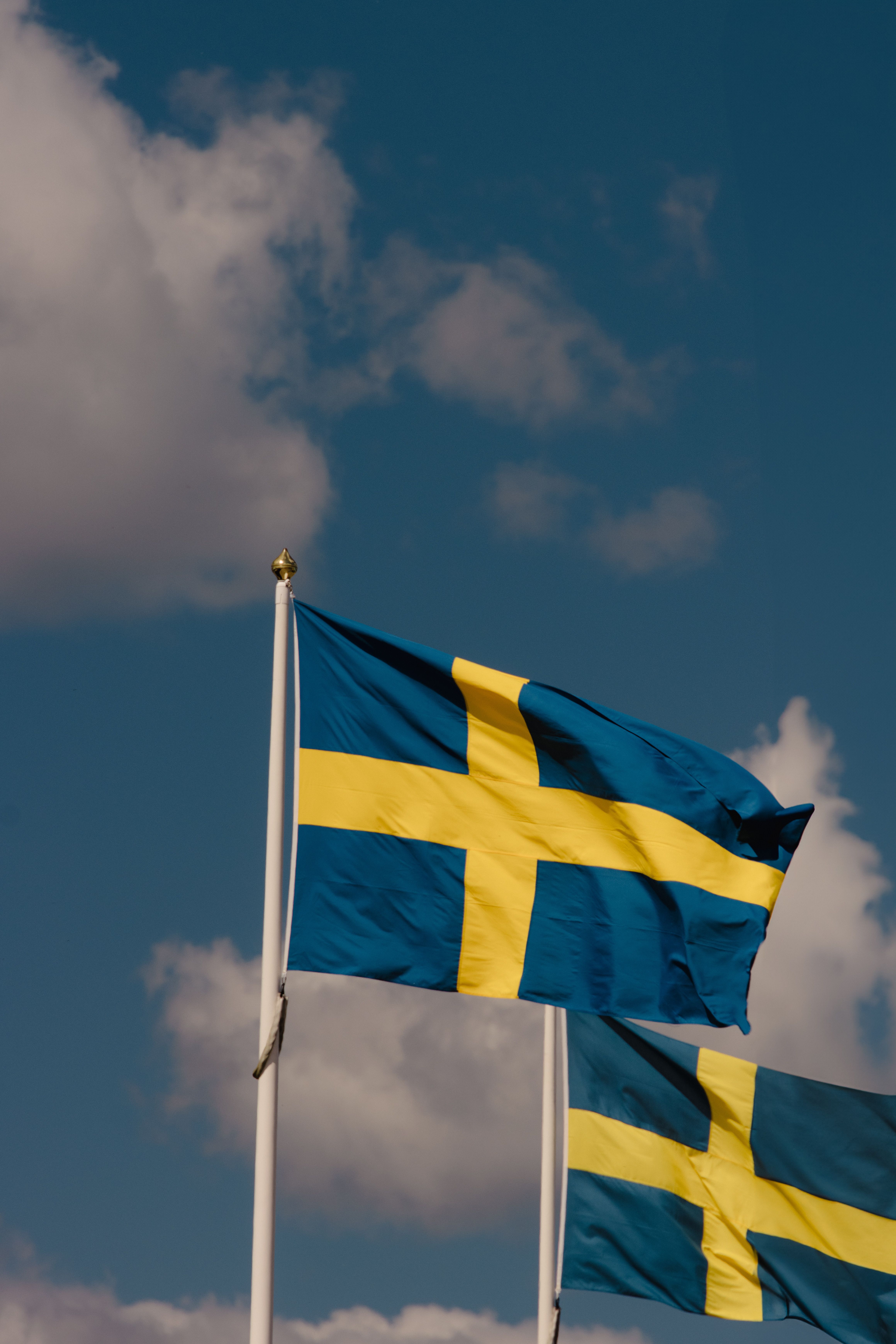 Swedish Flags Fluttering Against a Blue Sky · Free Stock Photo