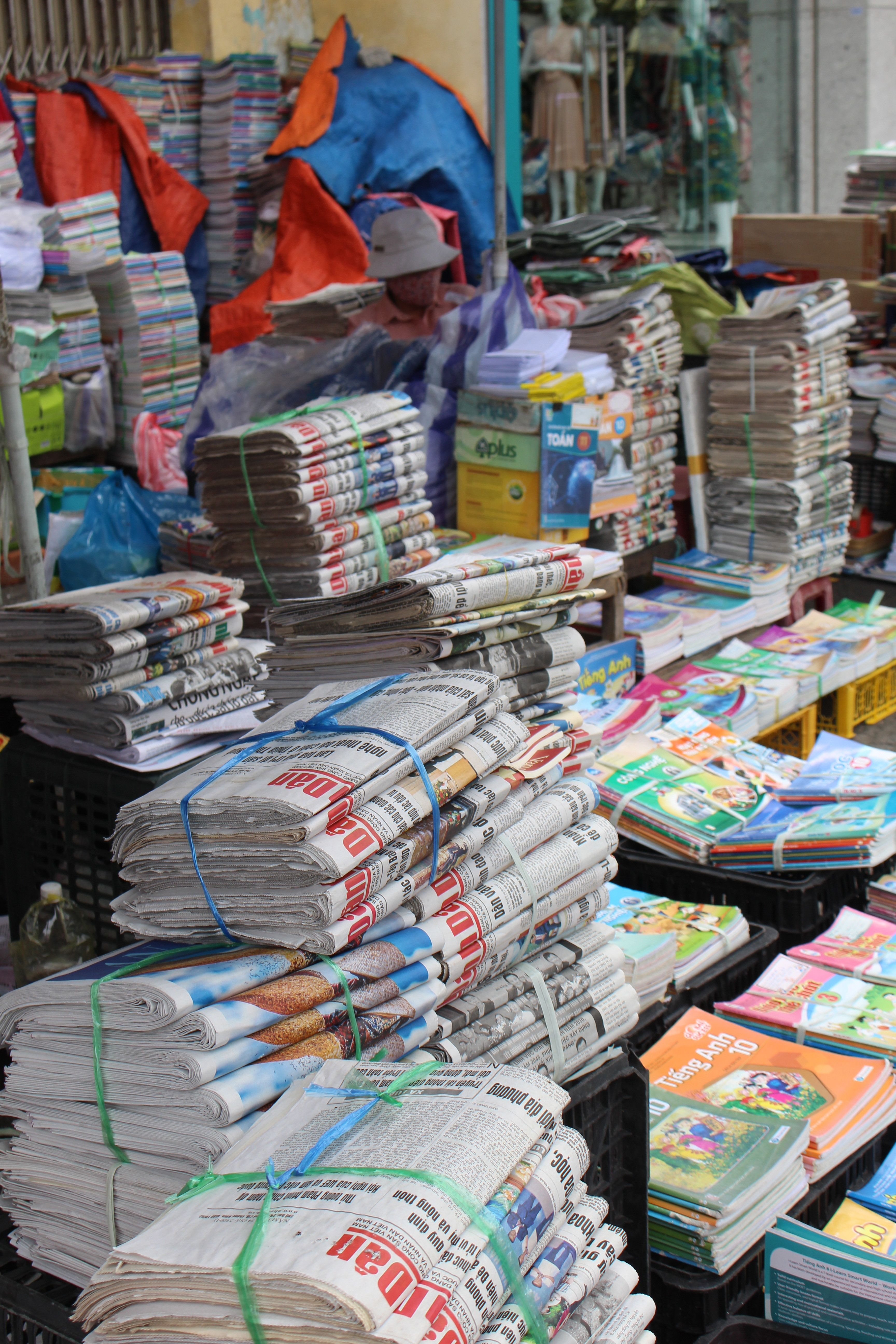 Stack of Printed Newspapers on Outdoor Vendor Table · Free Stock Photo