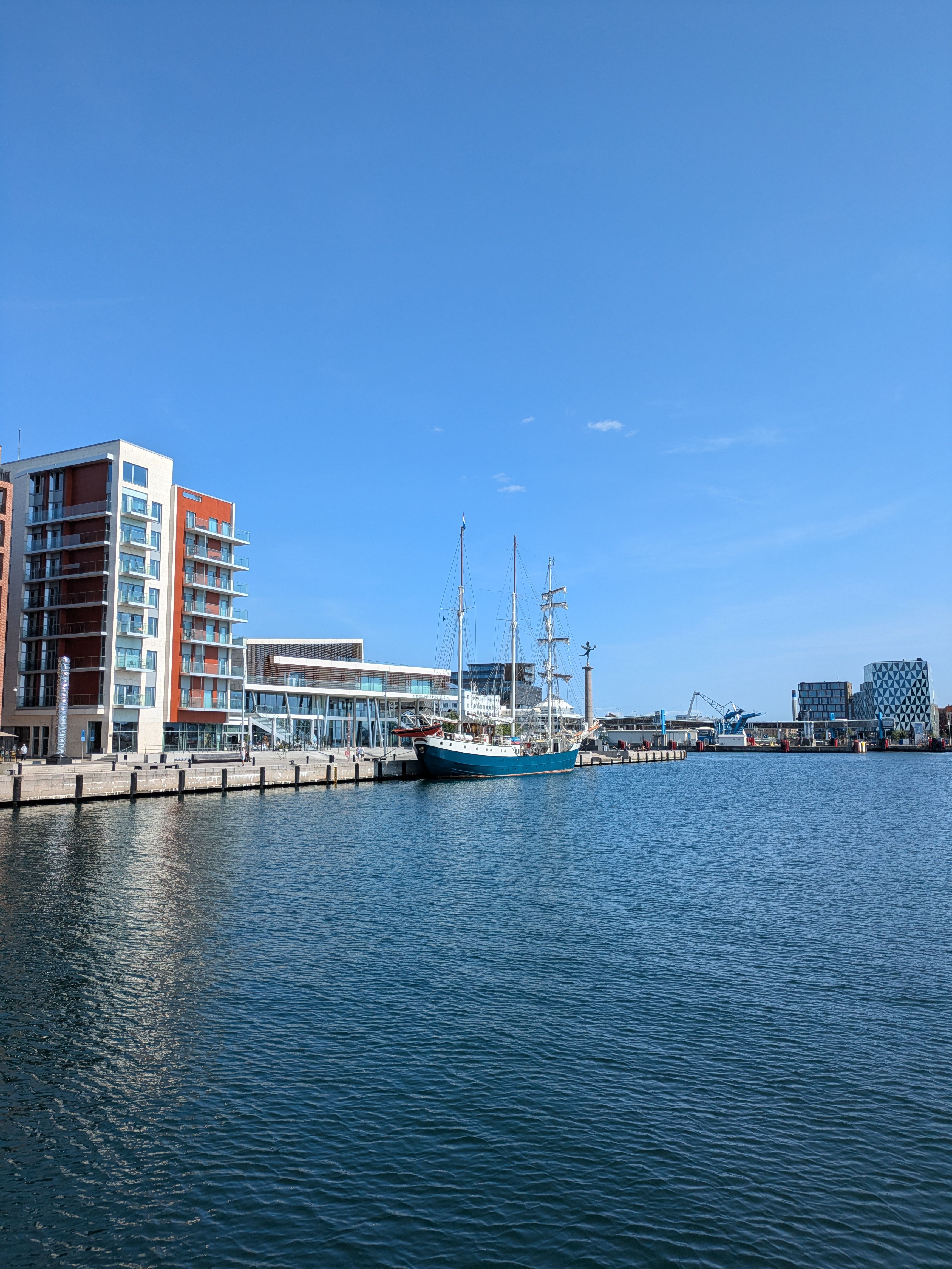 Beautiful Harbor View with Sailboat and Modern Buildings · Free Stock Photo