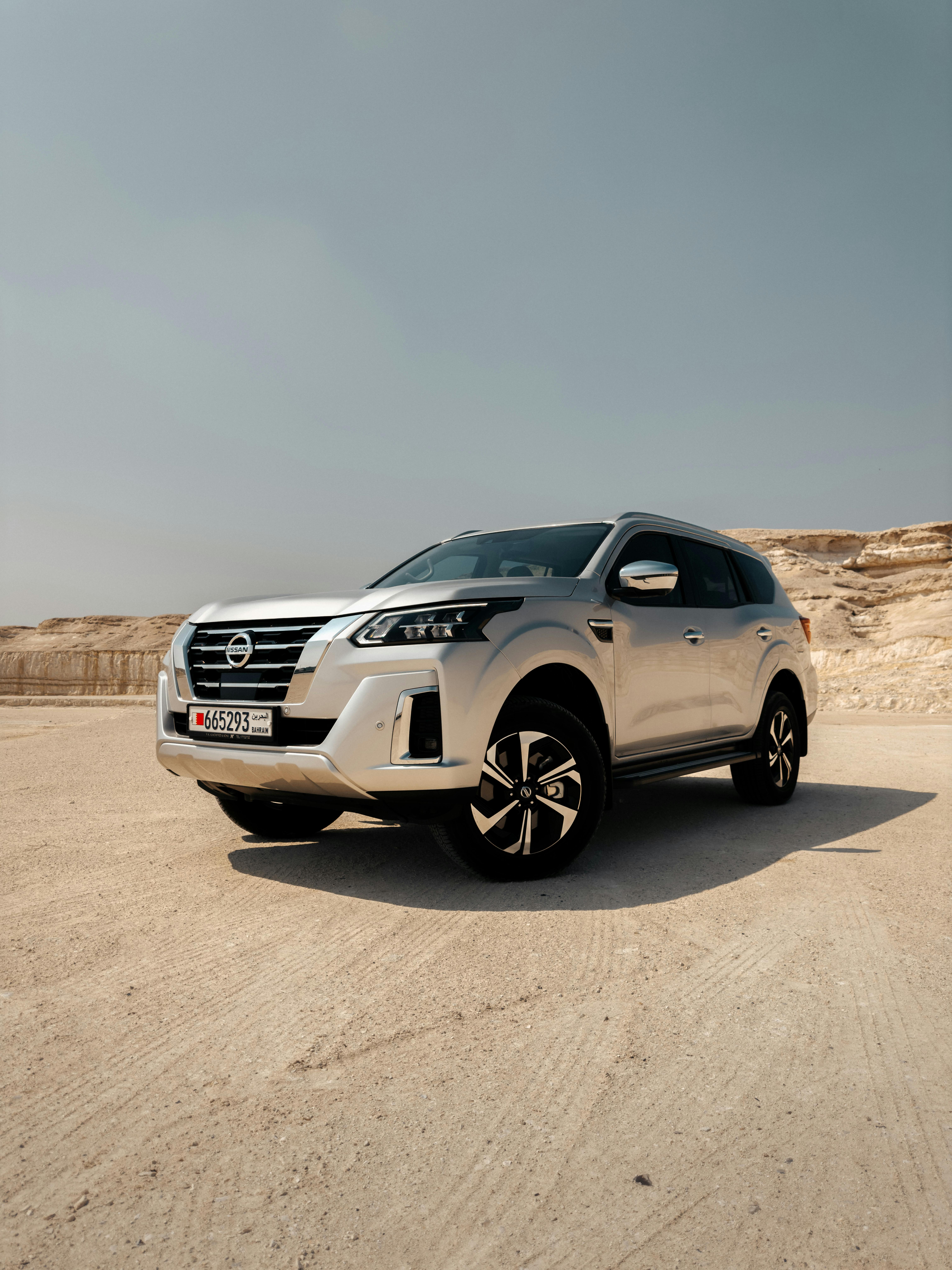 Silver SUV in Desert Landscape Under Clear Sky · Free Stock Photo