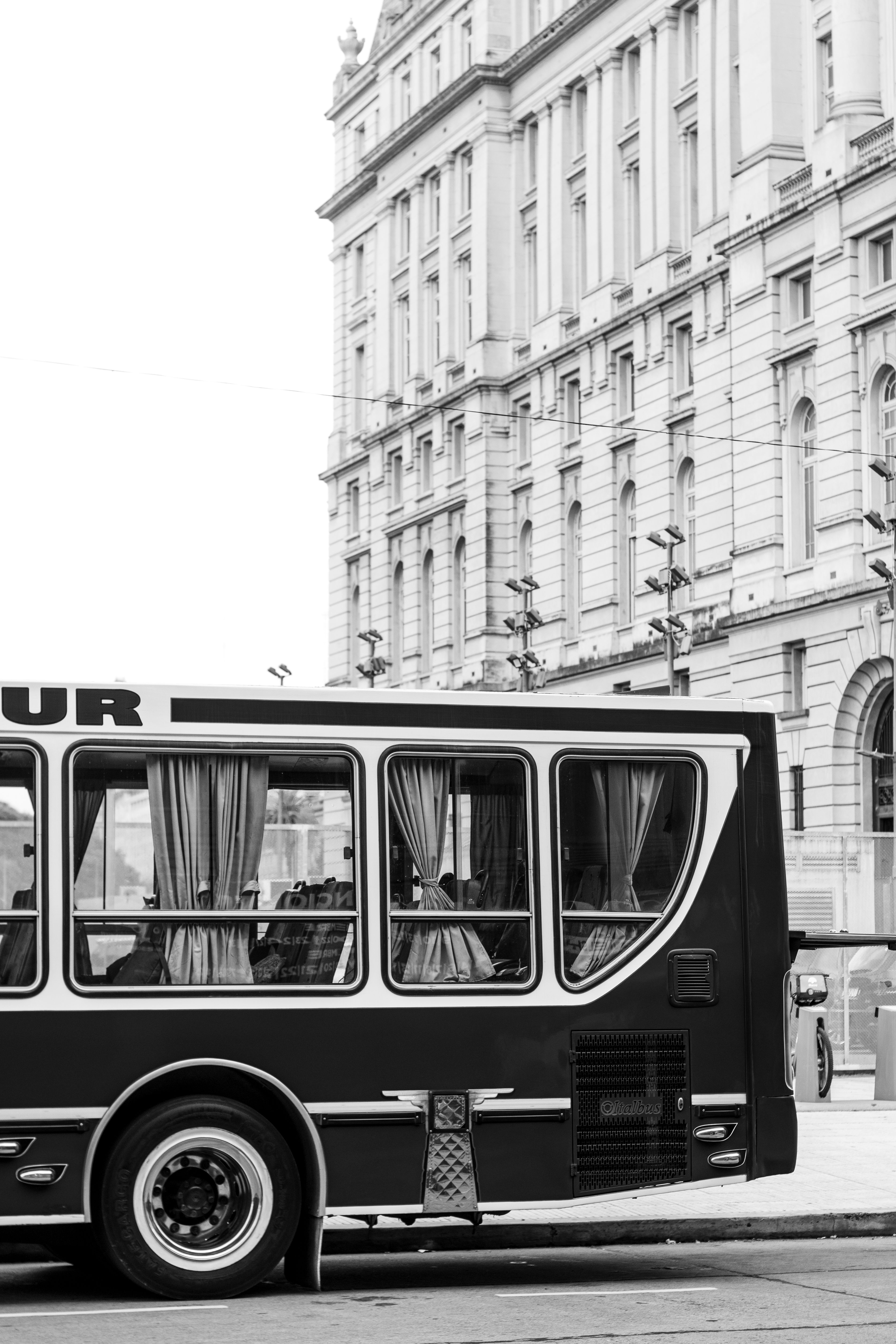 Black and White City Bus Near Historic Building · Free Stock Photo