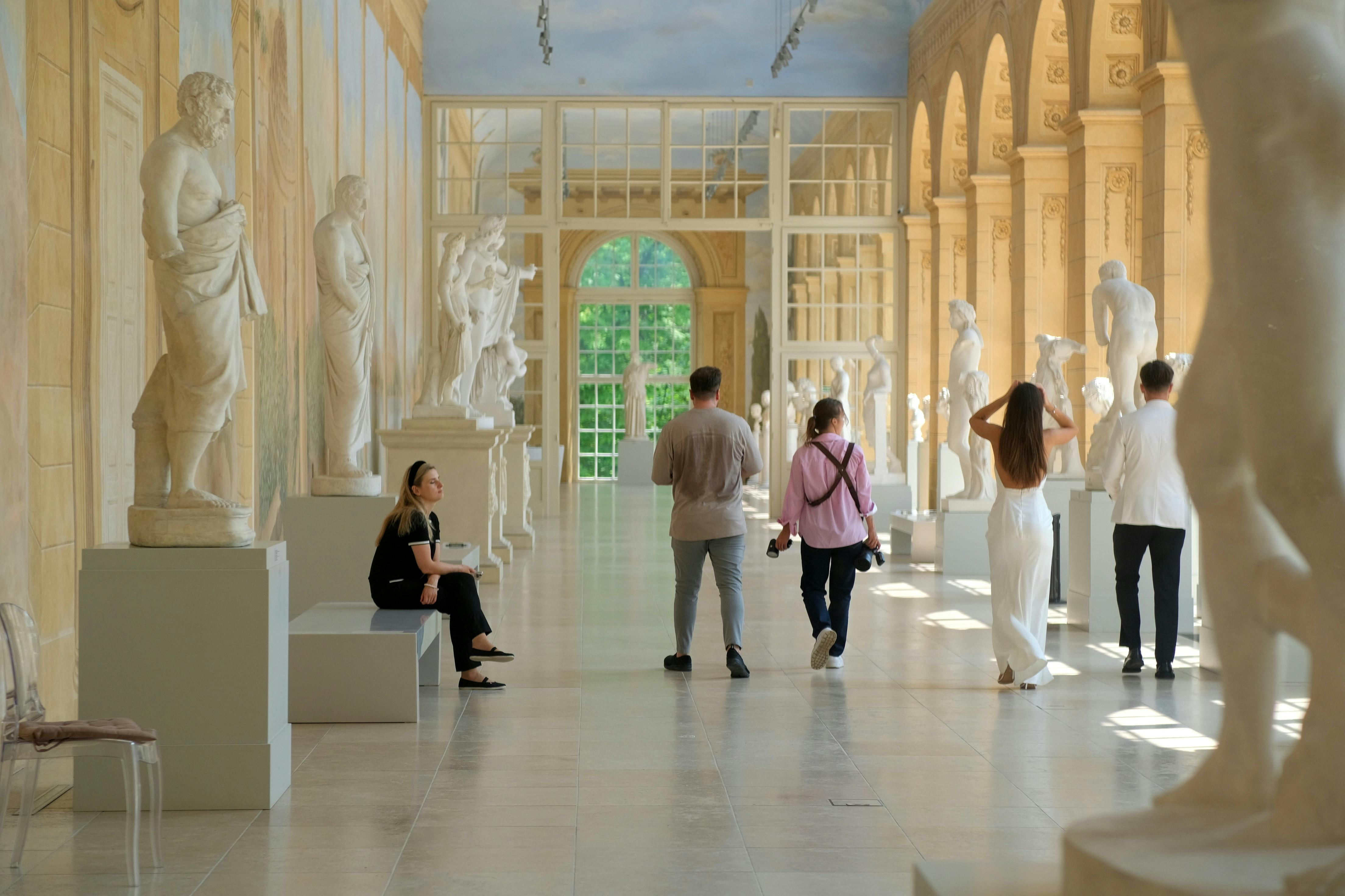 Tourists exploring classical sculpture gallery · Free Stock Photo