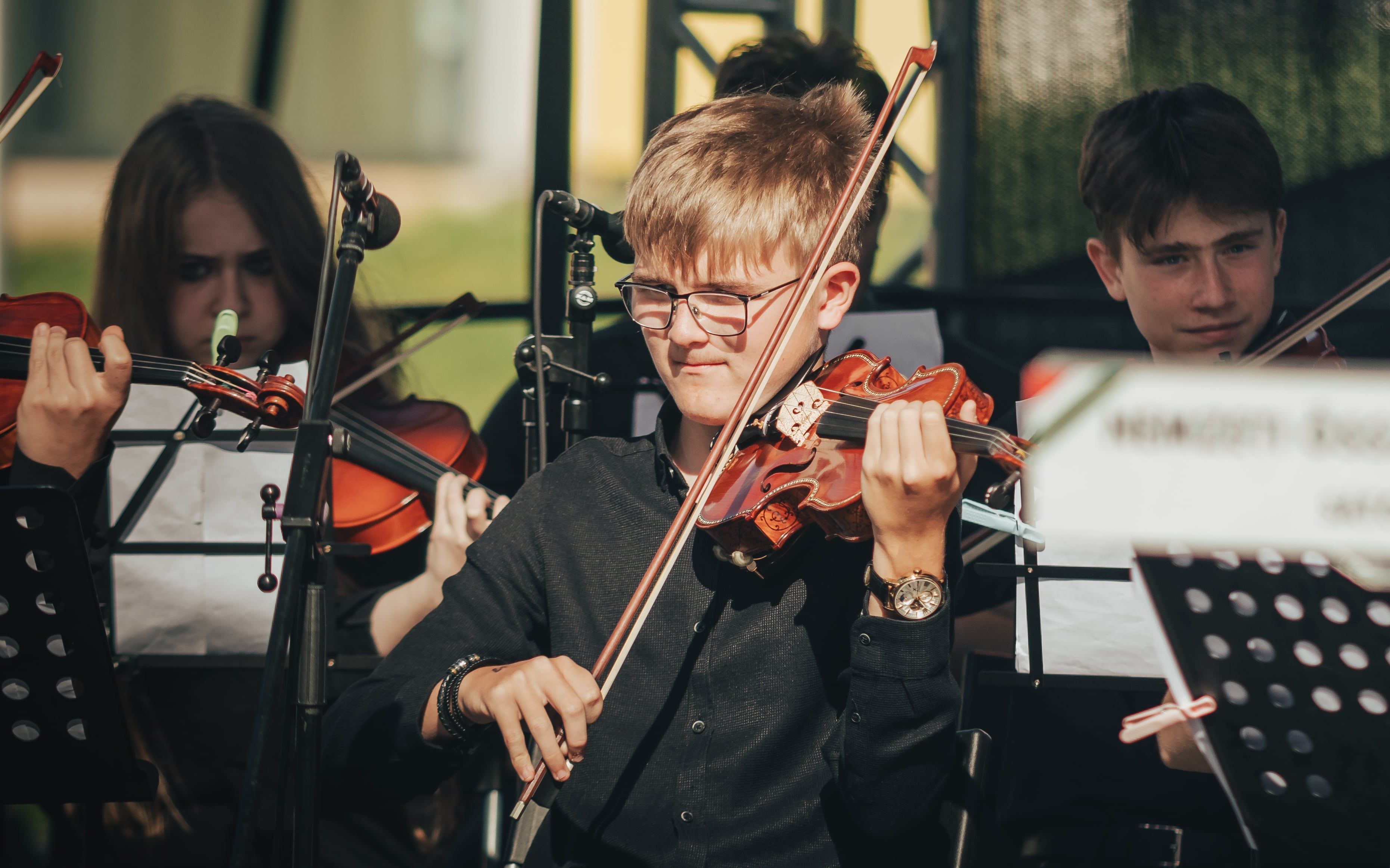 Youth Orchestra Performing Outdoors with Violins · Free Stock Photo