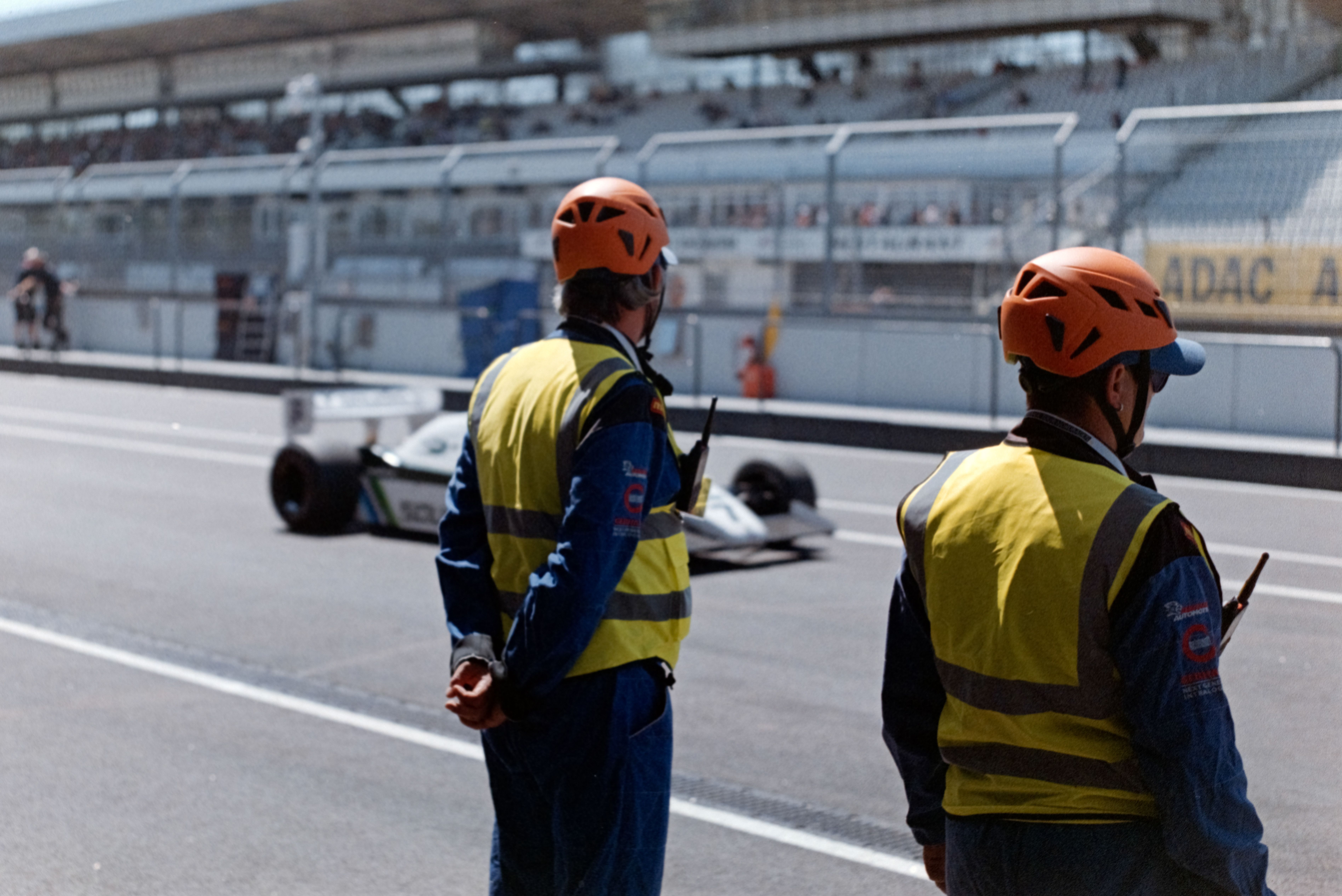 Race Officials Overseeing Car on Track · Free Stock Photo