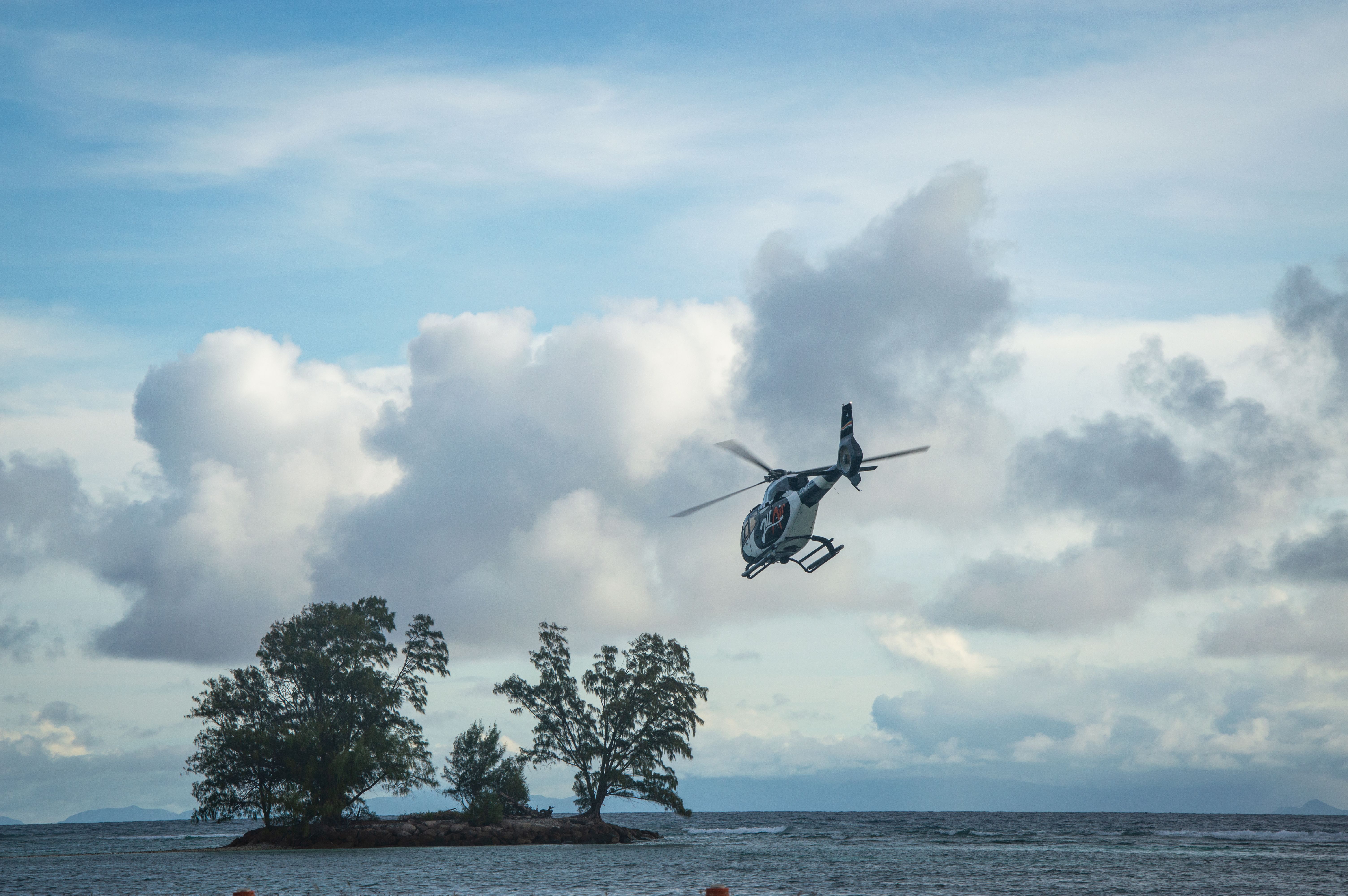 Helicopter Flying Over Tropical Island at Daytime · Free Stock Photo