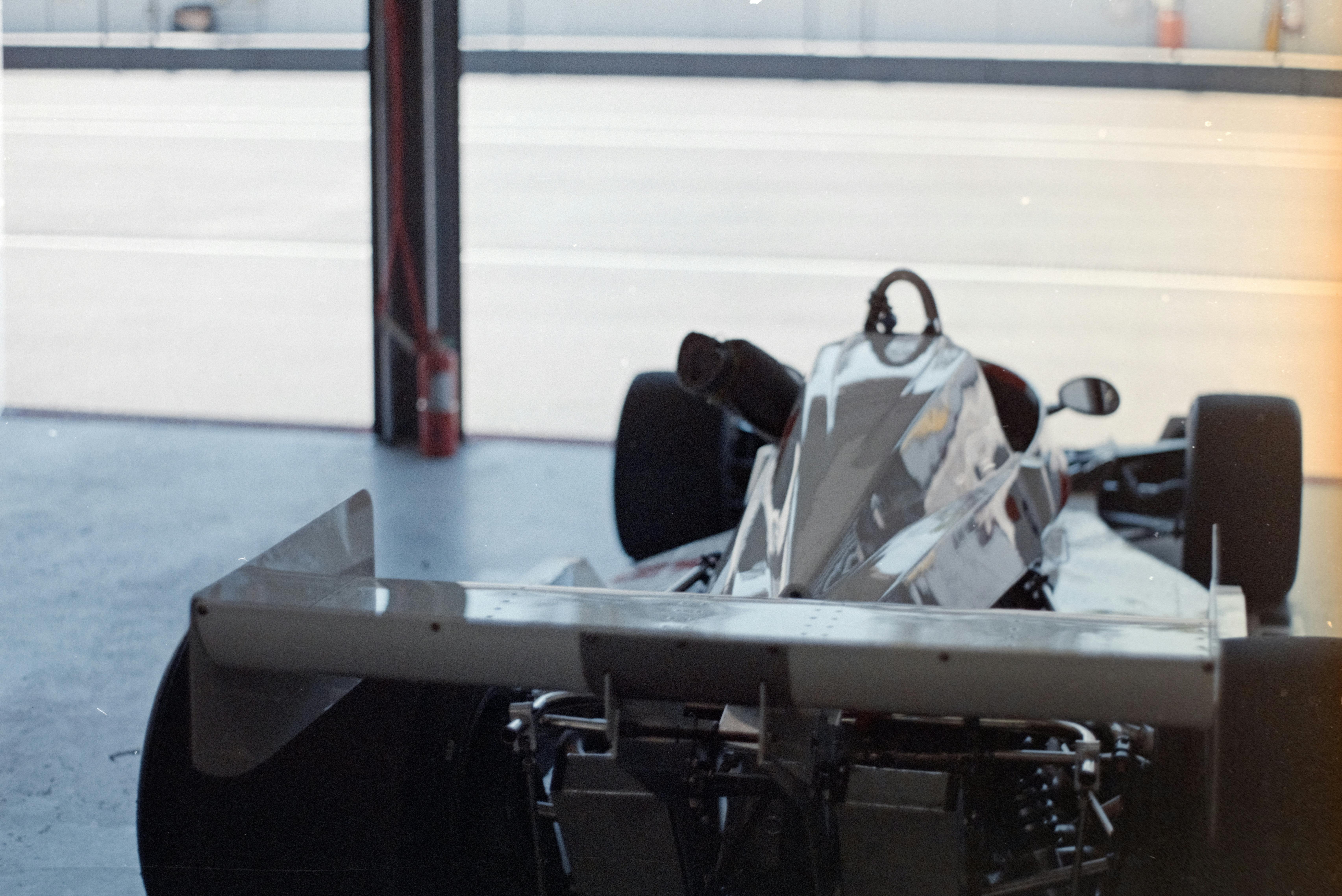 F1 Driver Statue Beside F1 Car · Free Stock Photo
