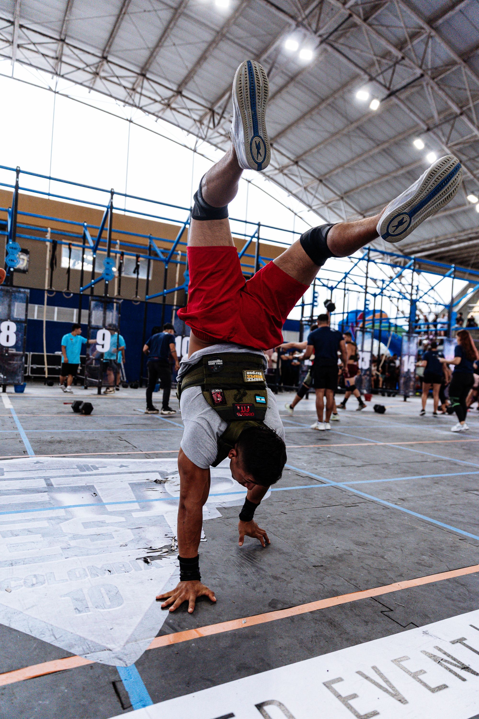 Man Performing Handstand at Indoor Gym Event · Free Stock Photo