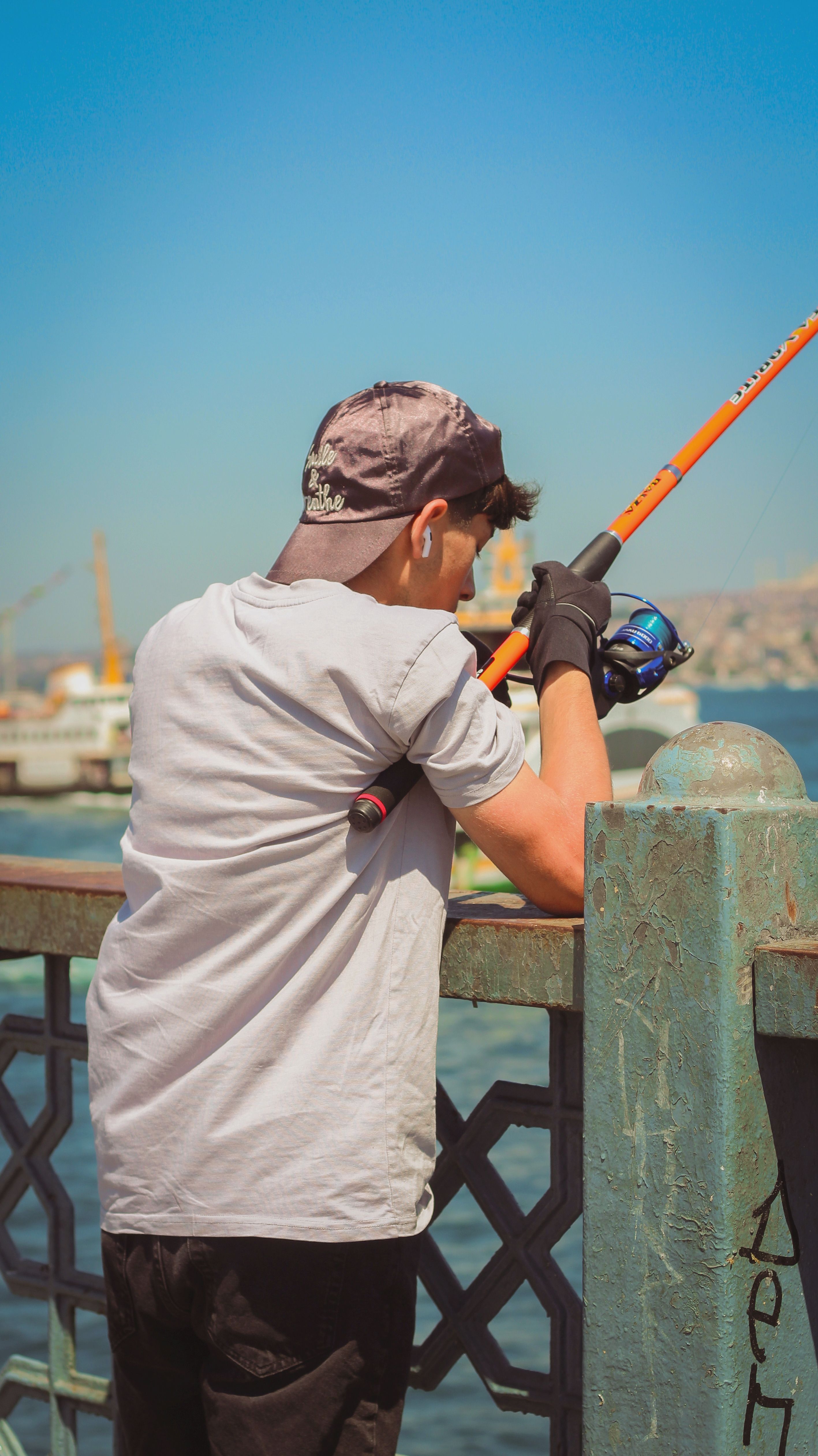 Man Fishing from Bridge on a Sunny Day · Free Stock Photo