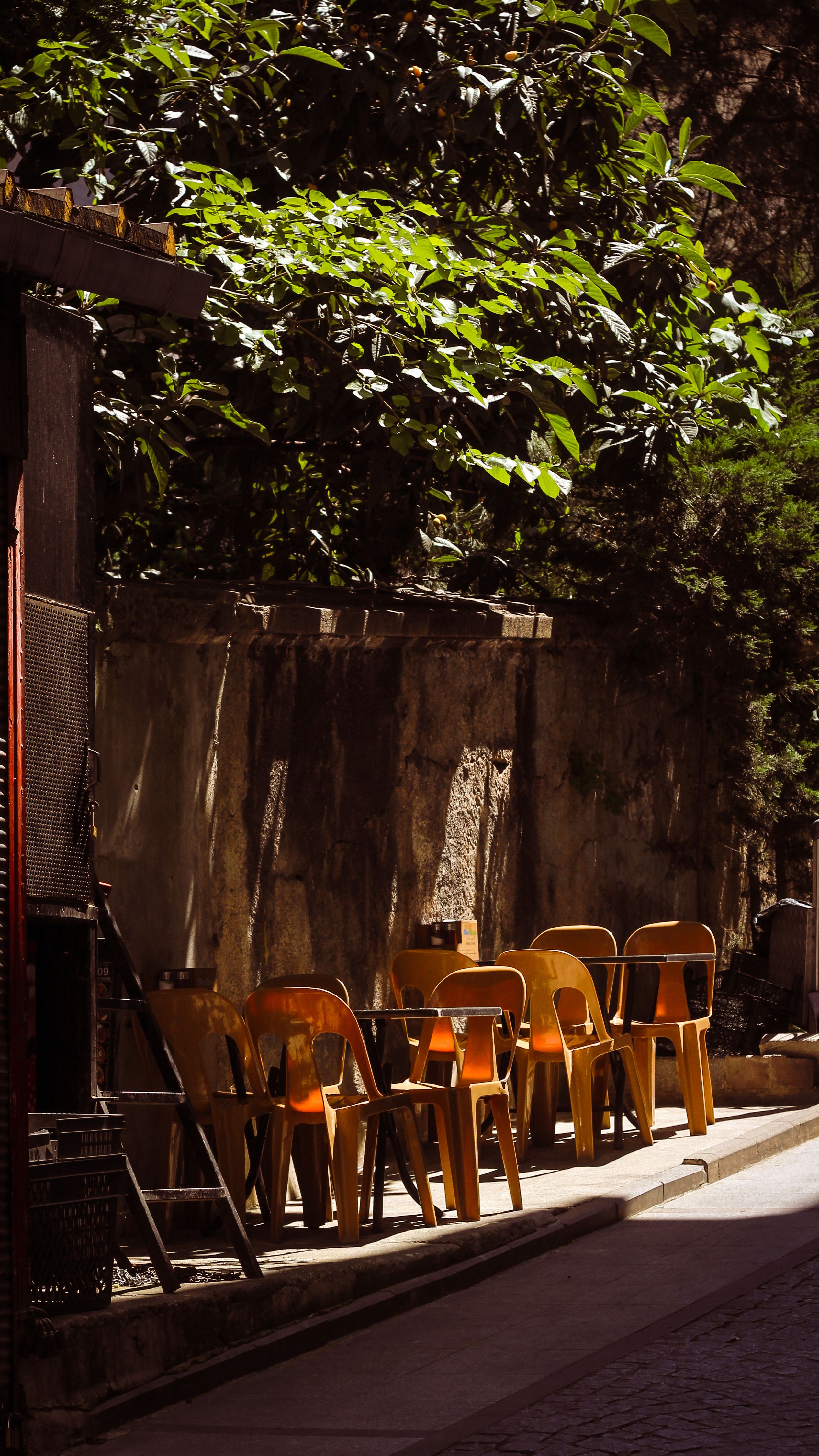 Sunlit Outdoor Cafe Seating in Alleyway · Free Stock Photo