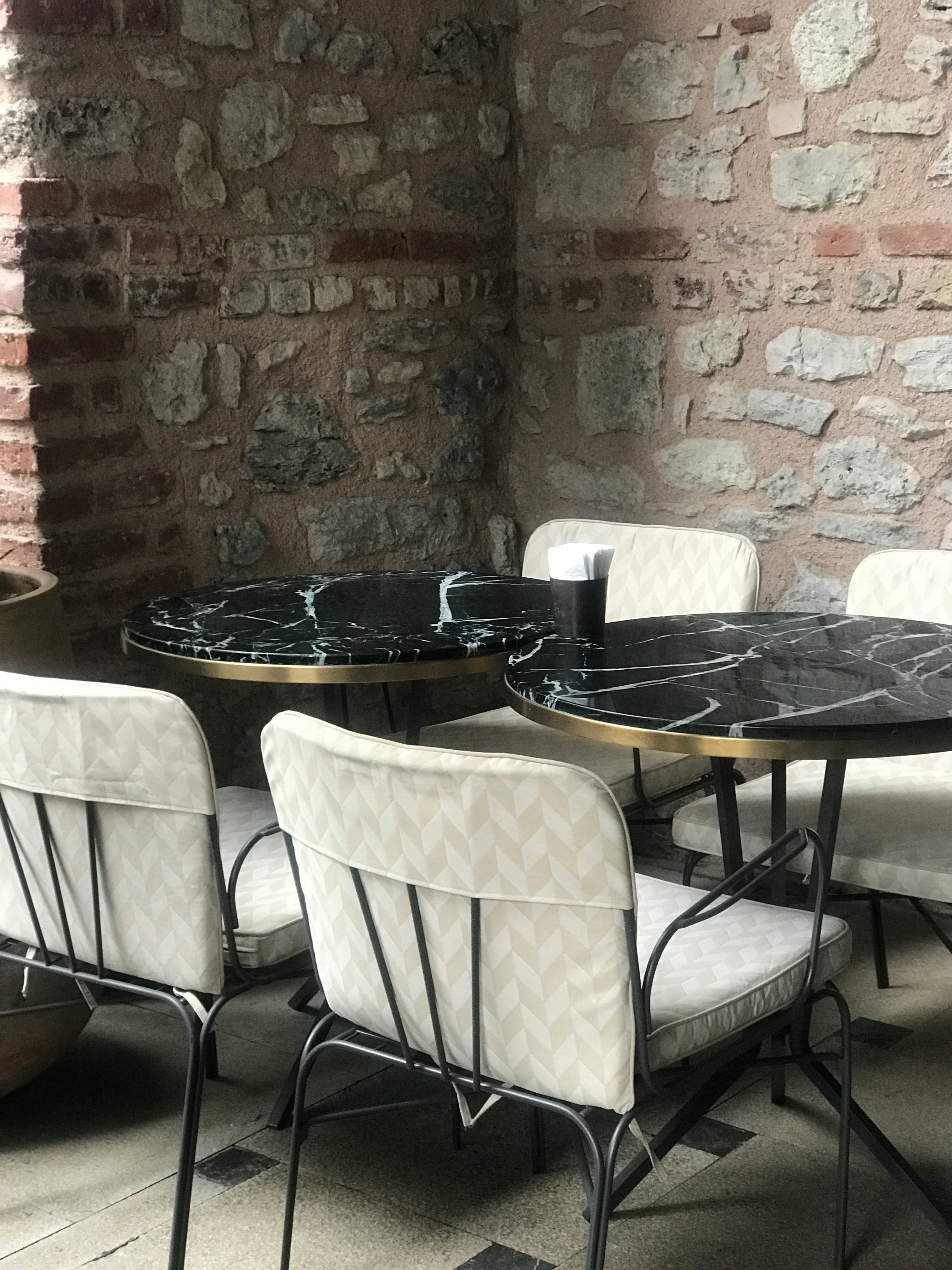 Elegant Outdoor Cafe Seating Area with Marble Tables · Free Stock Photo