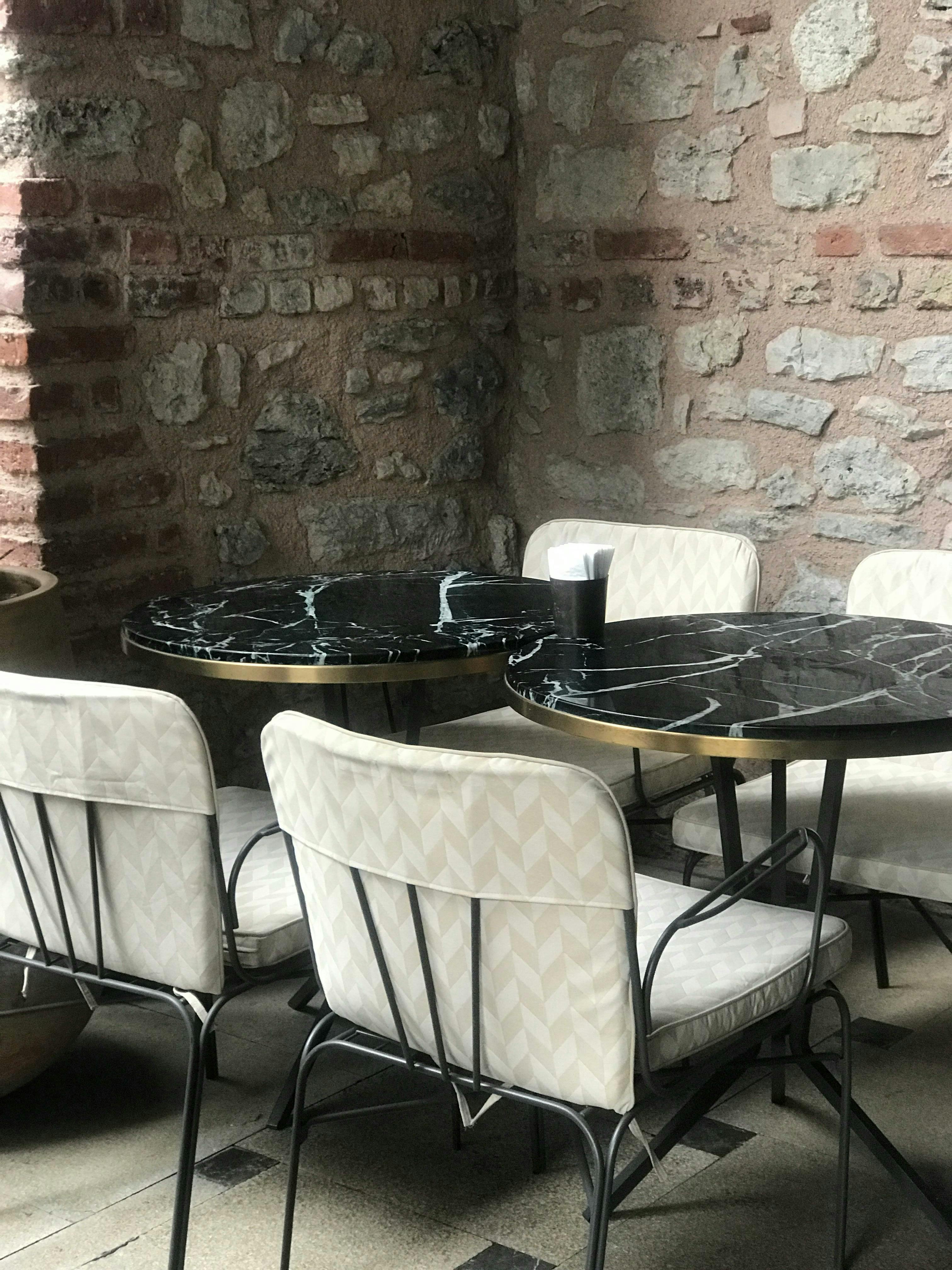 Elegant Outdoor Cafe Seating Area with Marble Tables · Free Stock Photo