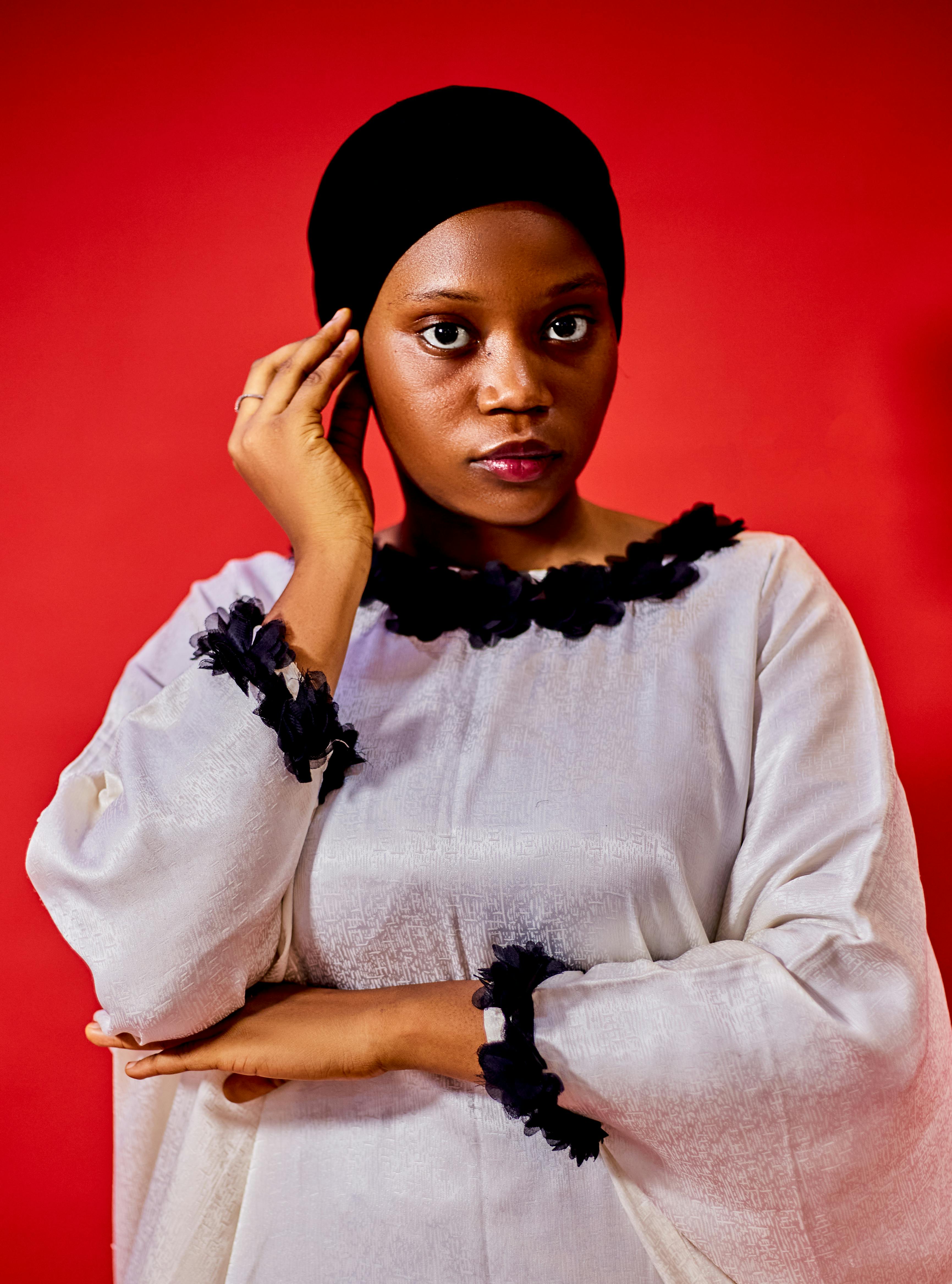 Portrait of a Woman in White Against Red Background · Free Stock Photo