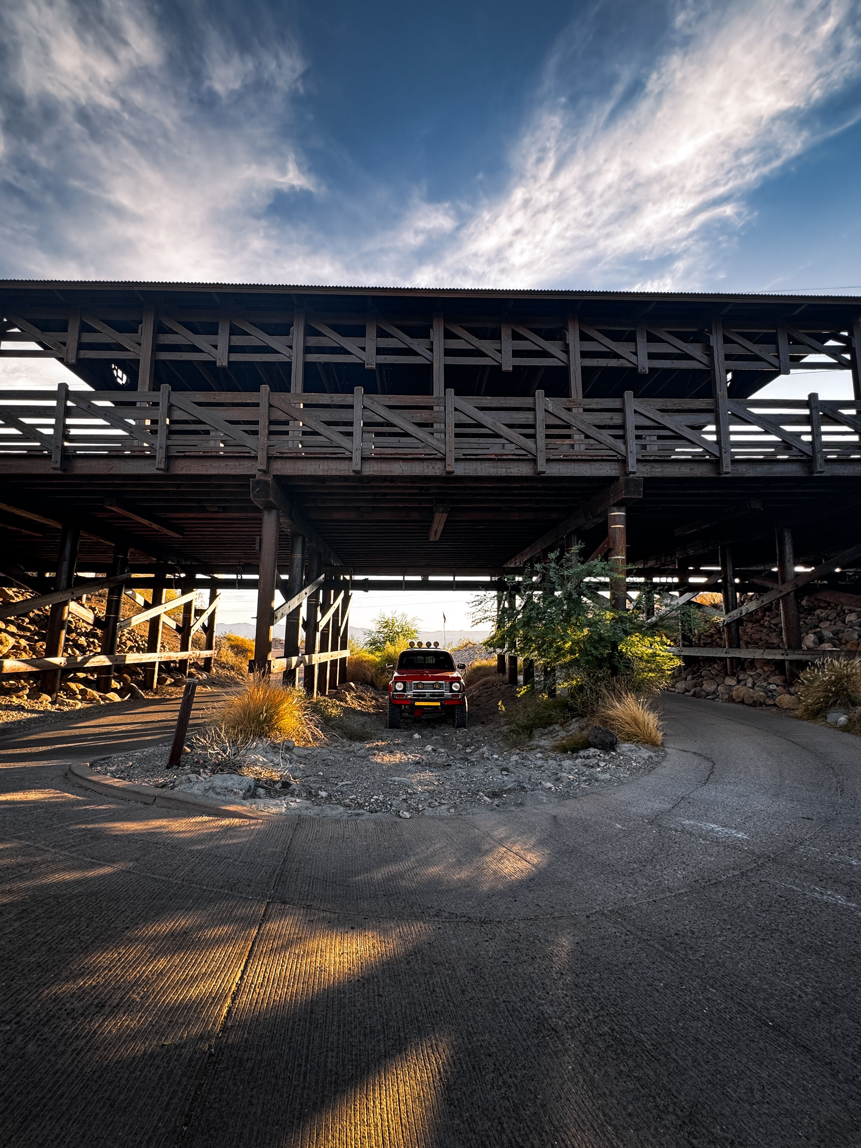 Red Off-Road Vehicle Under Industrial Structure · Free Stock Photo