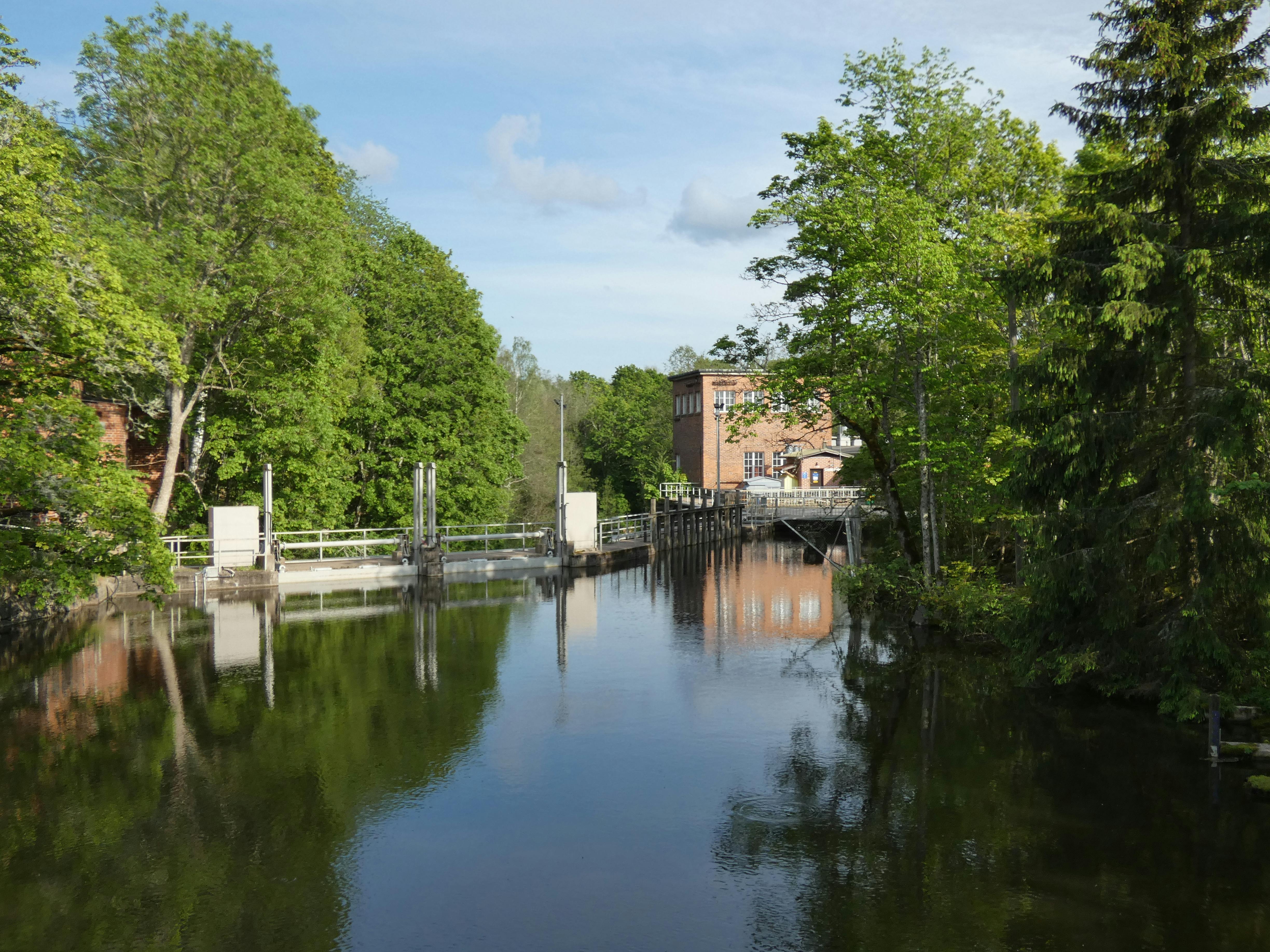 Idyllic River and Dam Scene with Lush Foliage · Free Stock Photo