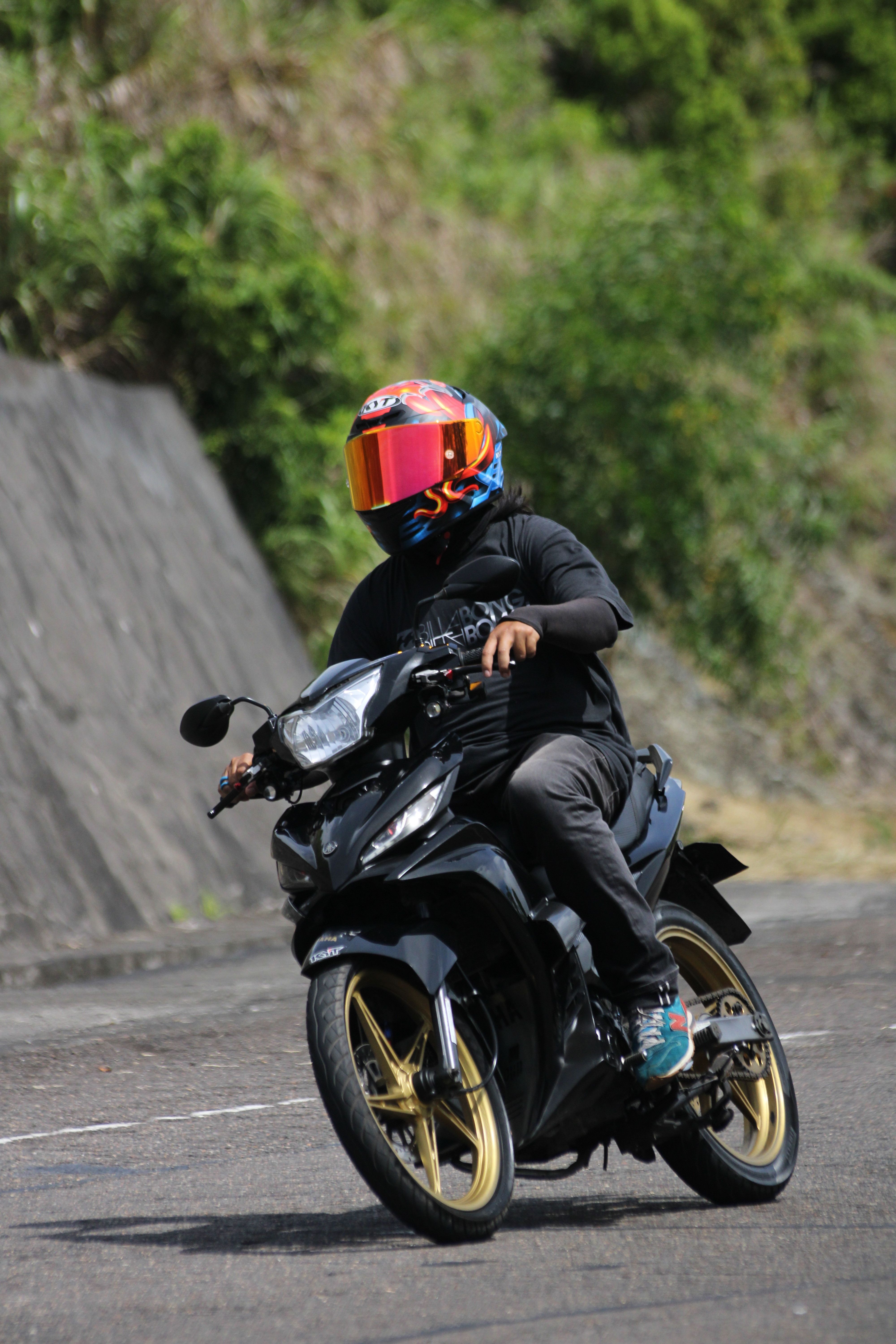 Motorcyclist with Colorful Helmet on Roadway · Free Stock Photo