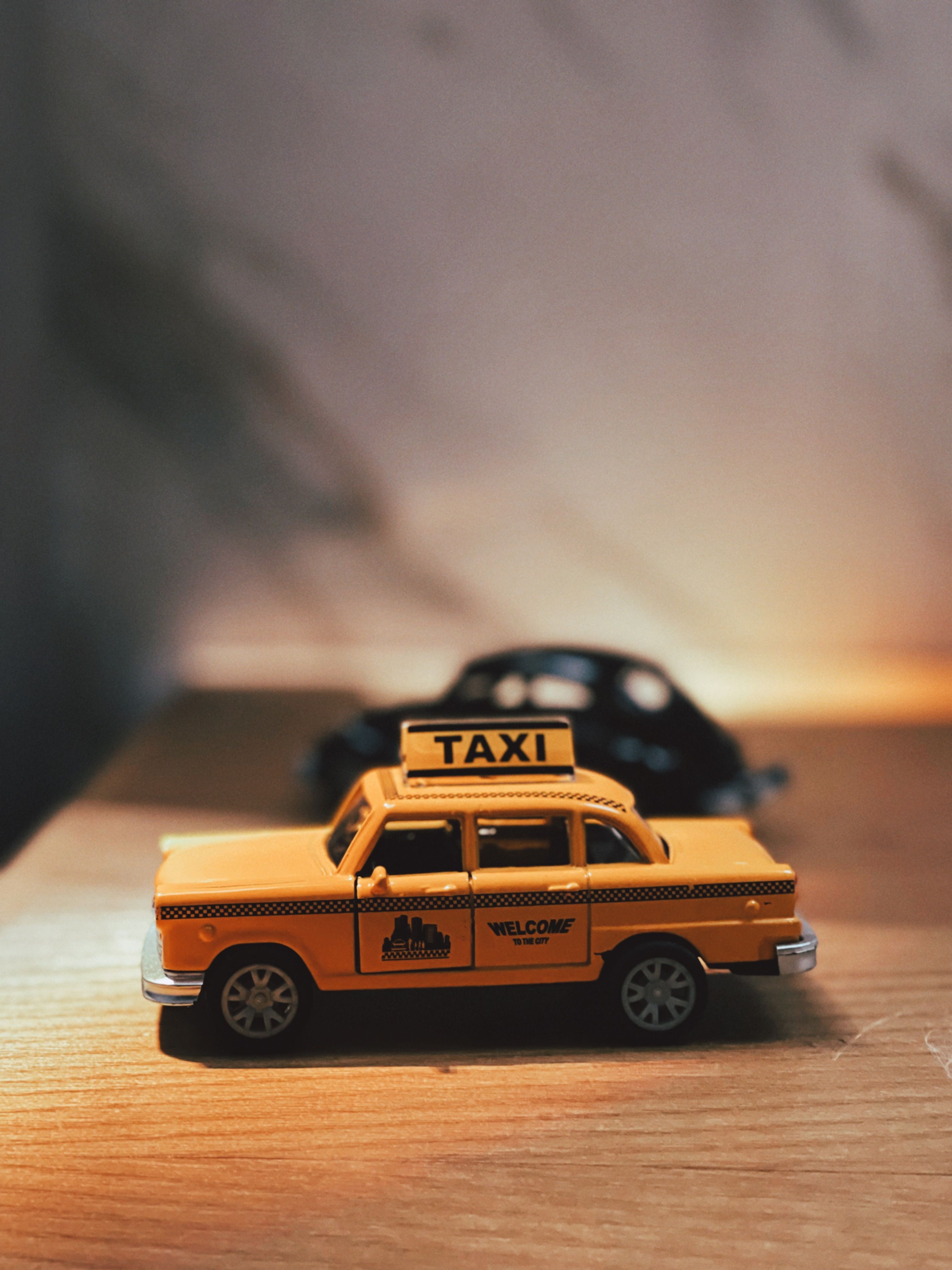 Close-Up of Small Toy Taxi on Wooden Surface · Free Stock Photo