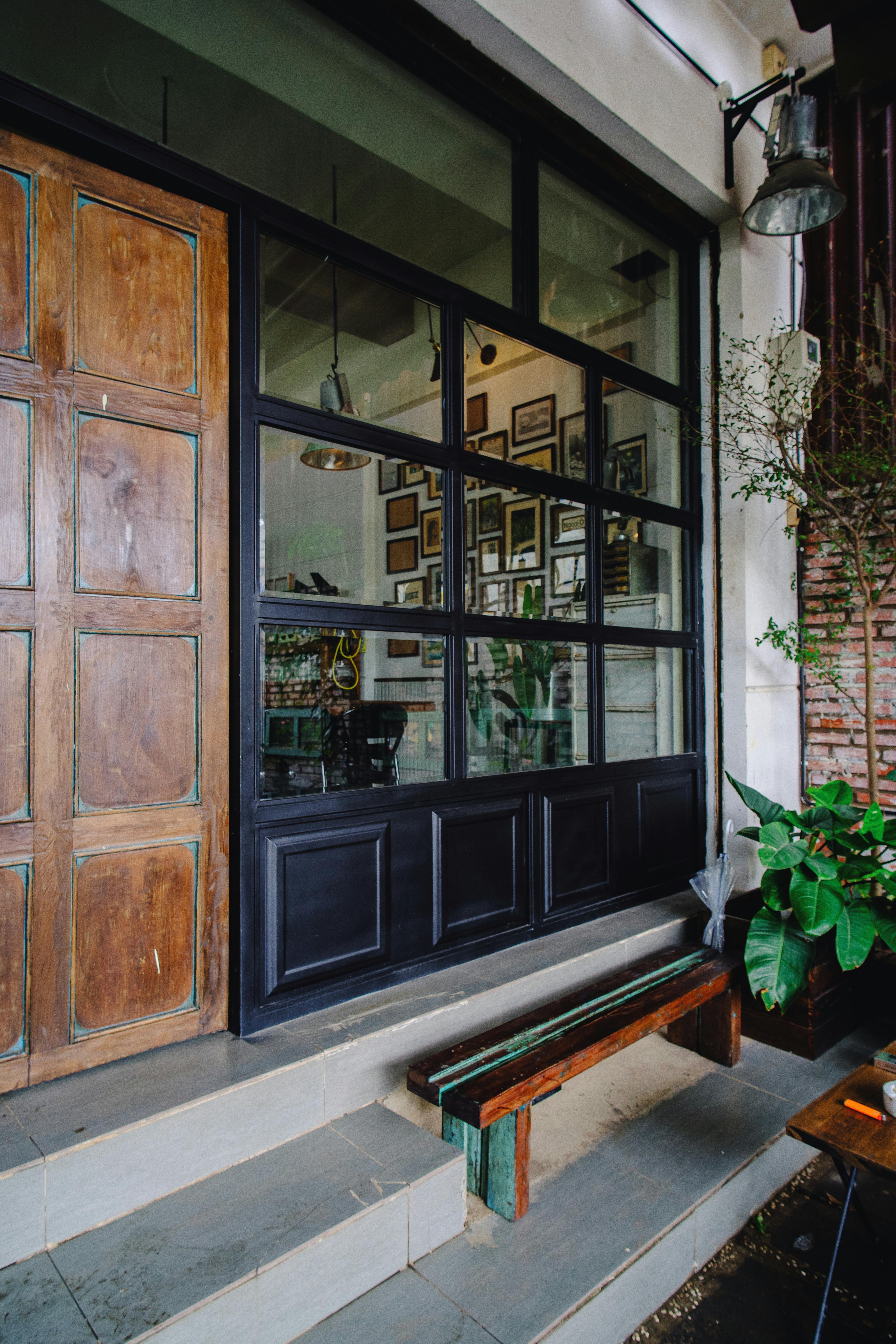 Rustic Coffee Shop Entrance with Greenery · Free Stock Photo