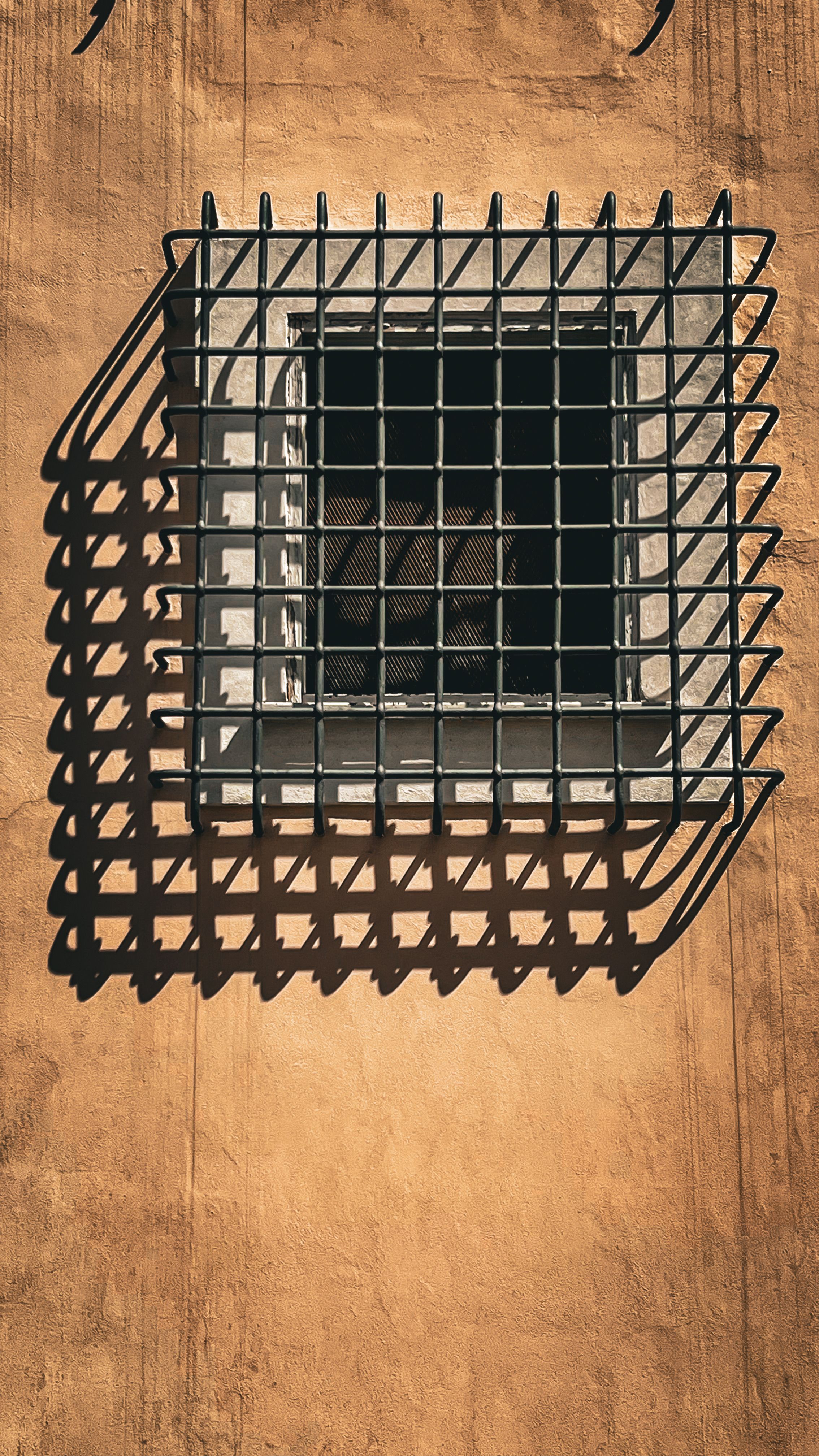 Shadow play on grilled window in sunlight · Free Stock Photo