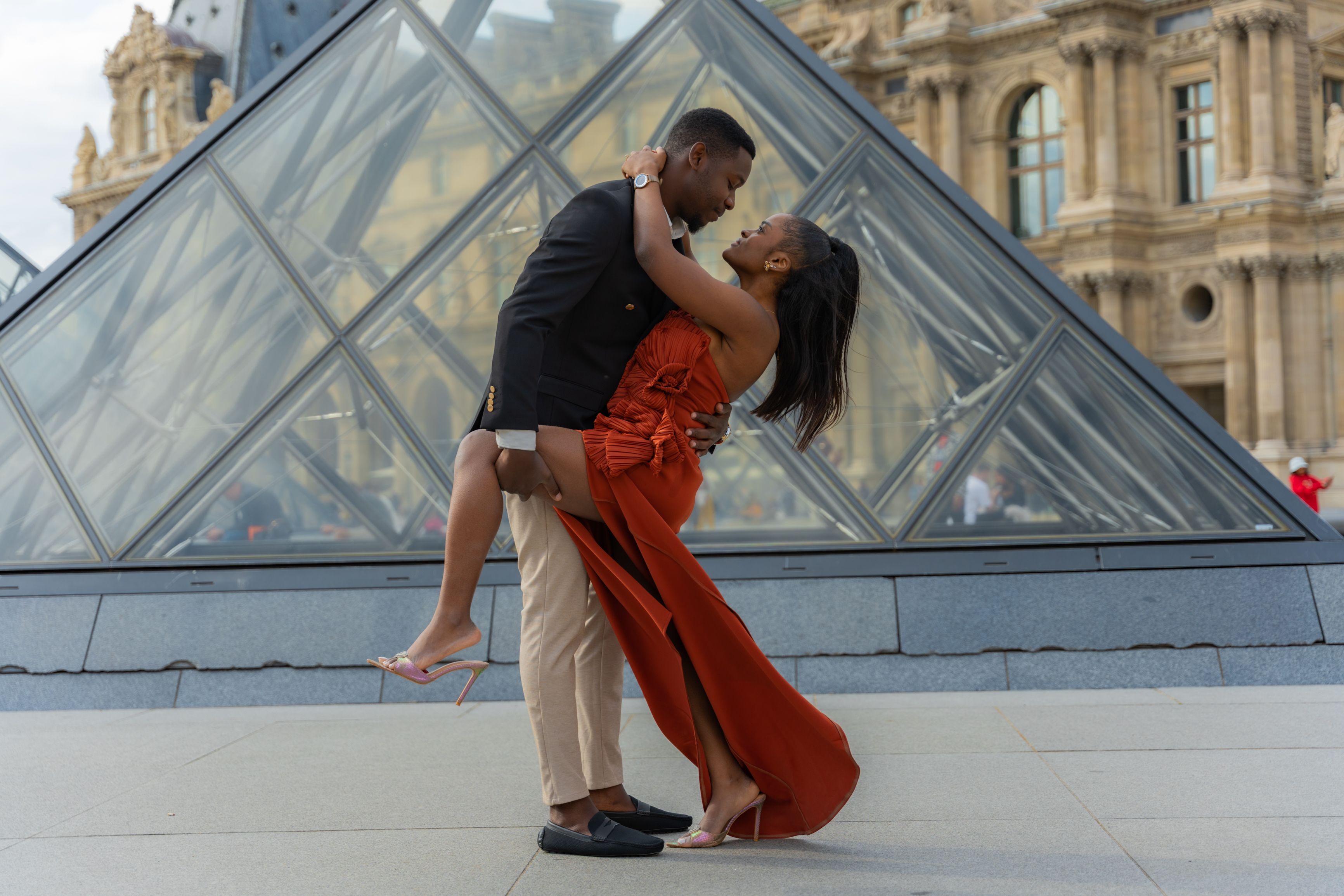 Romantic Couple Embracing at Louvre Pyramid · Free Stock Photo