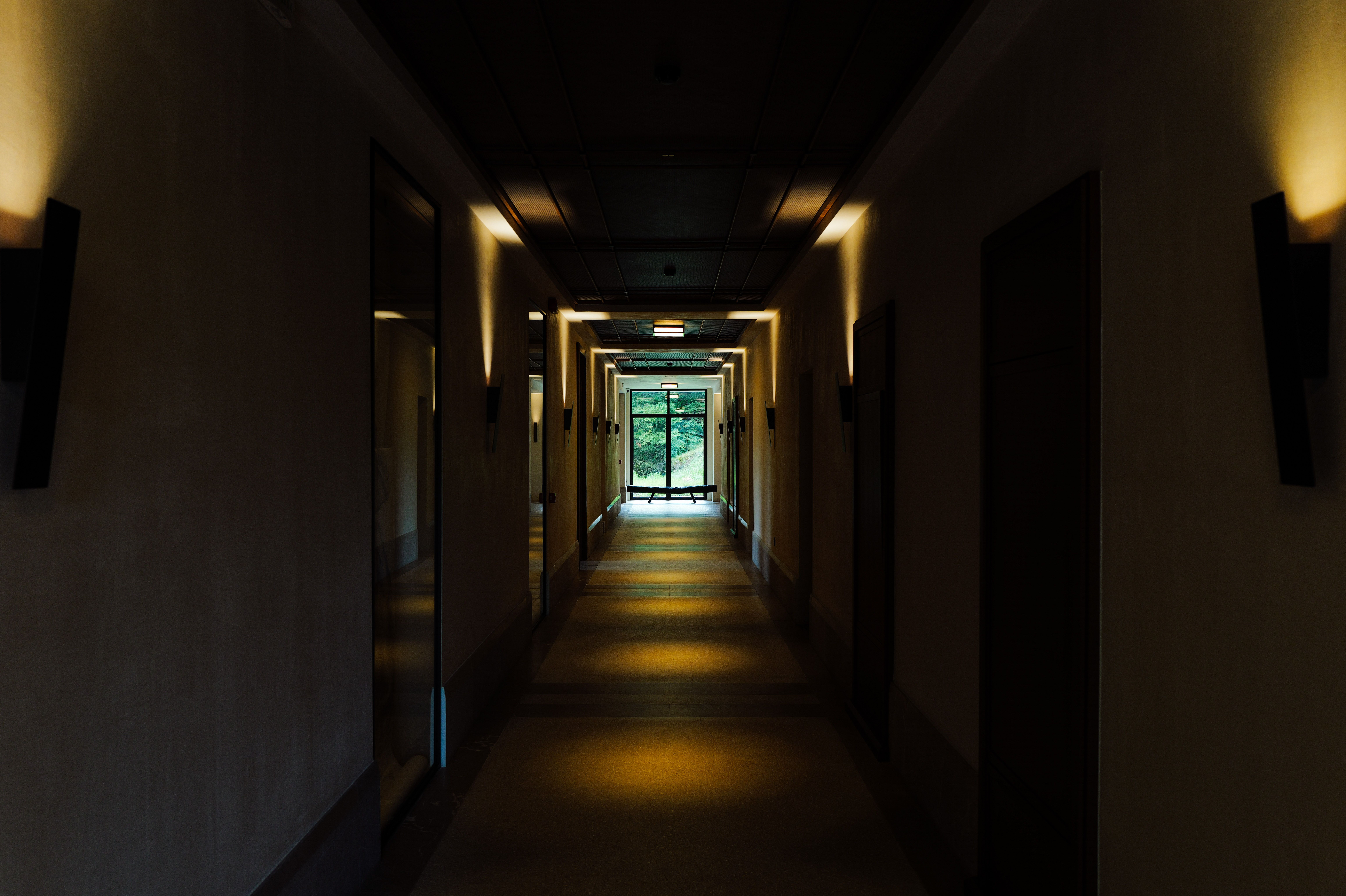 Dimly Lit Hotel Corridor Leading to Garden View · Free Stock Photo