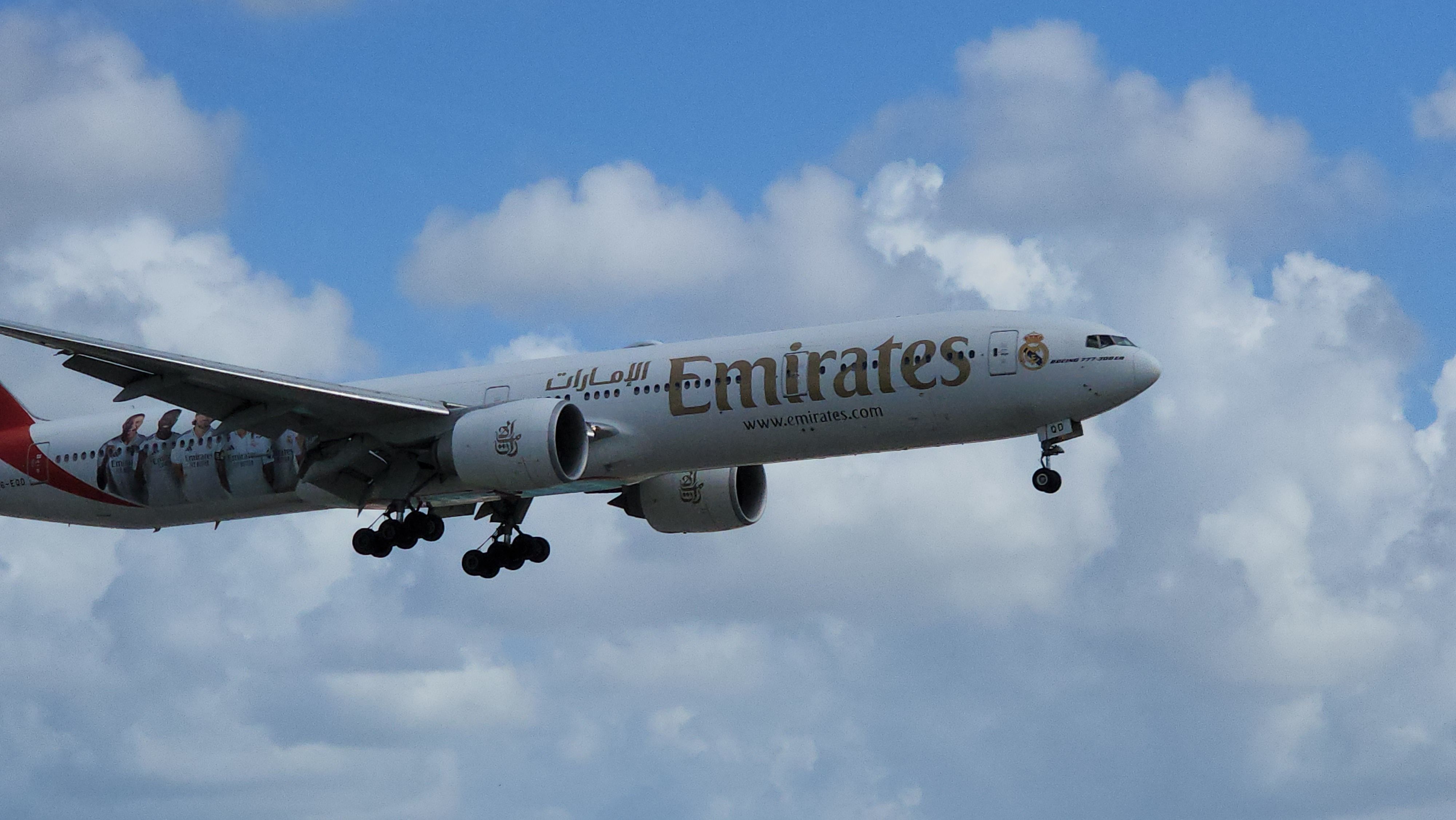 Emirates Aircraft in Flight Against Blue Sky · Free Stock Photo