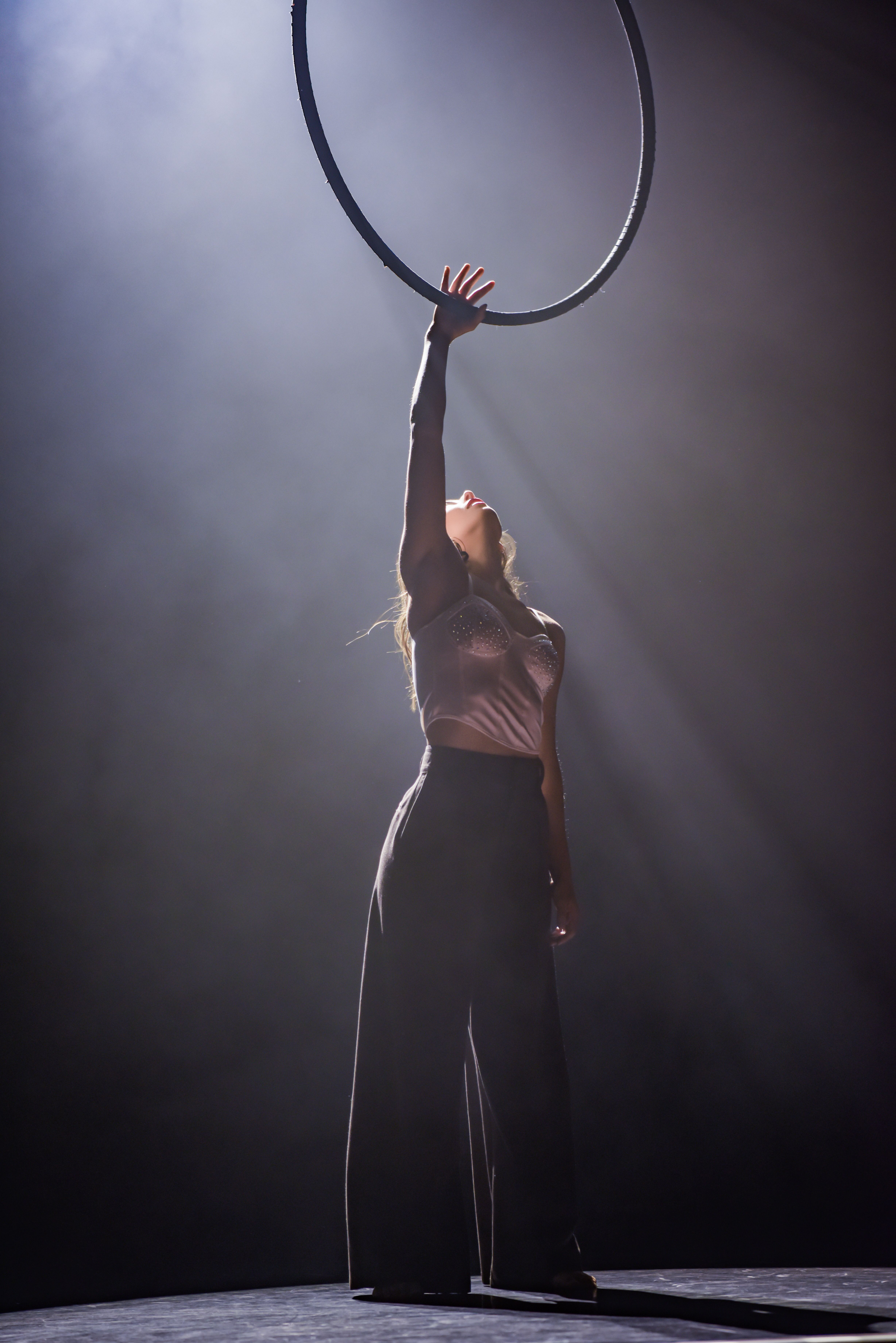 Aerial Performer Reaching for Hoop in Spotlight · Free Stock Photo