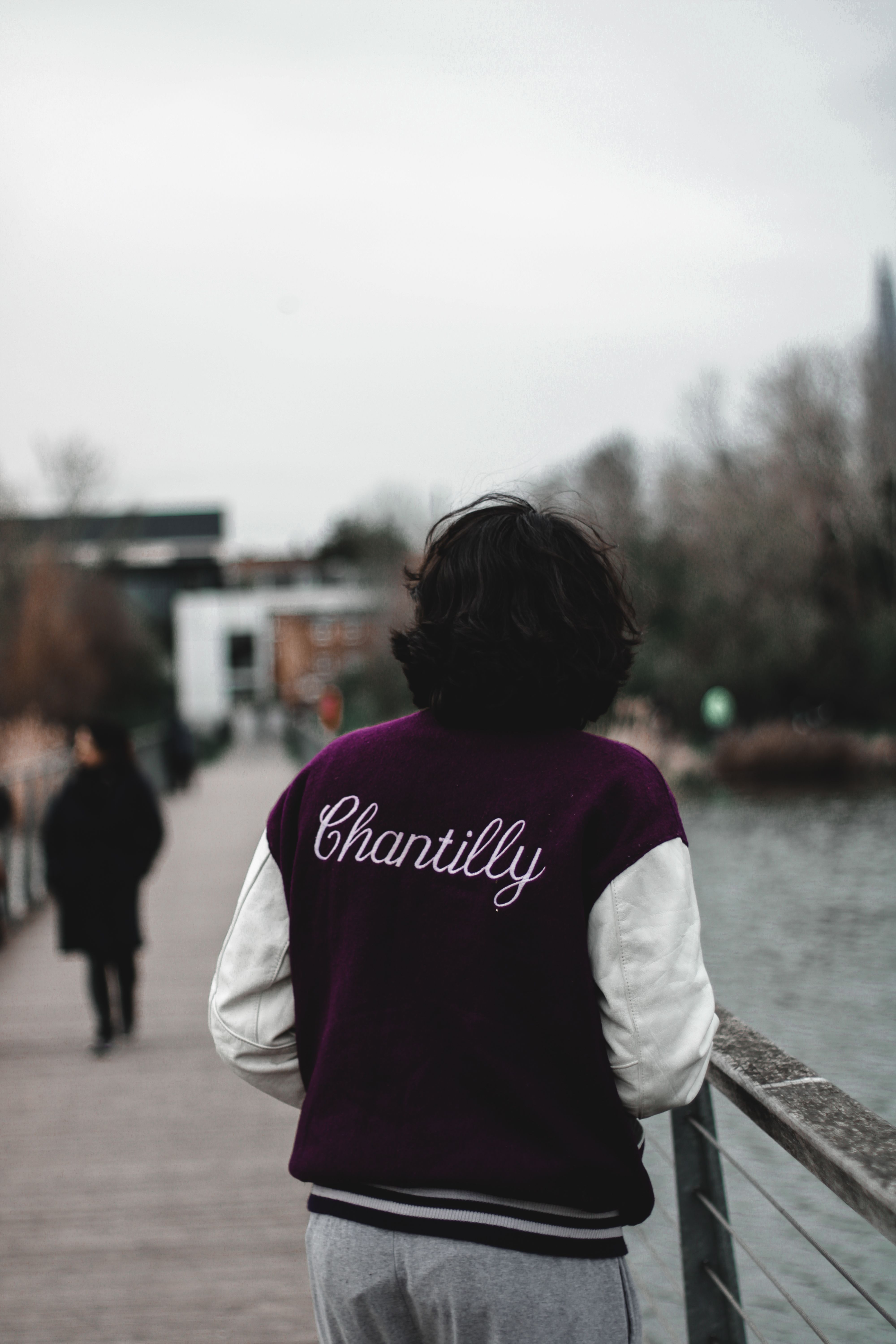 Young Woman in Letterman Jacket on Bridge in England · Free Stock Photo