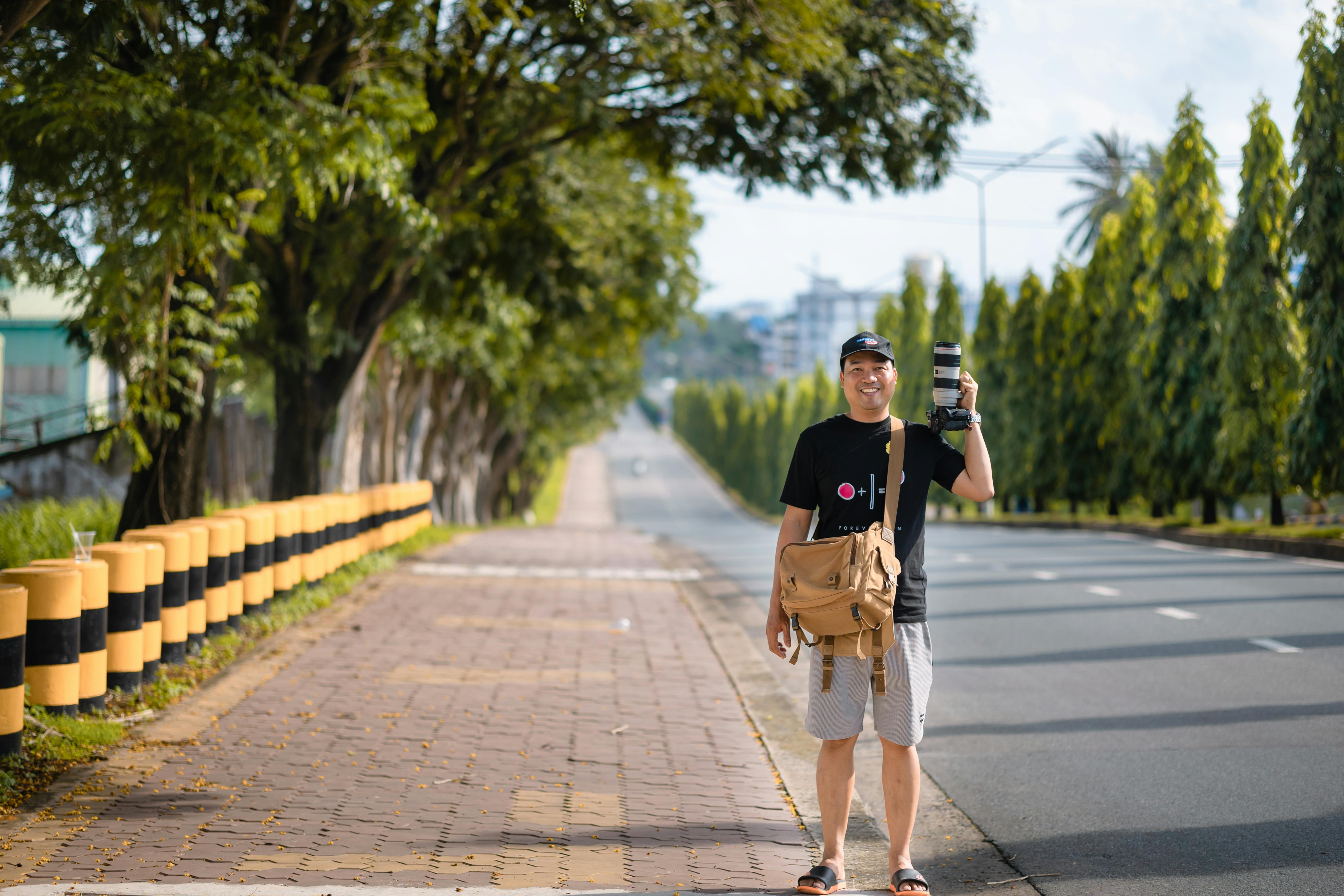 Photographer on a Sunny Pathway with Camera Gear · Free Stock Photo