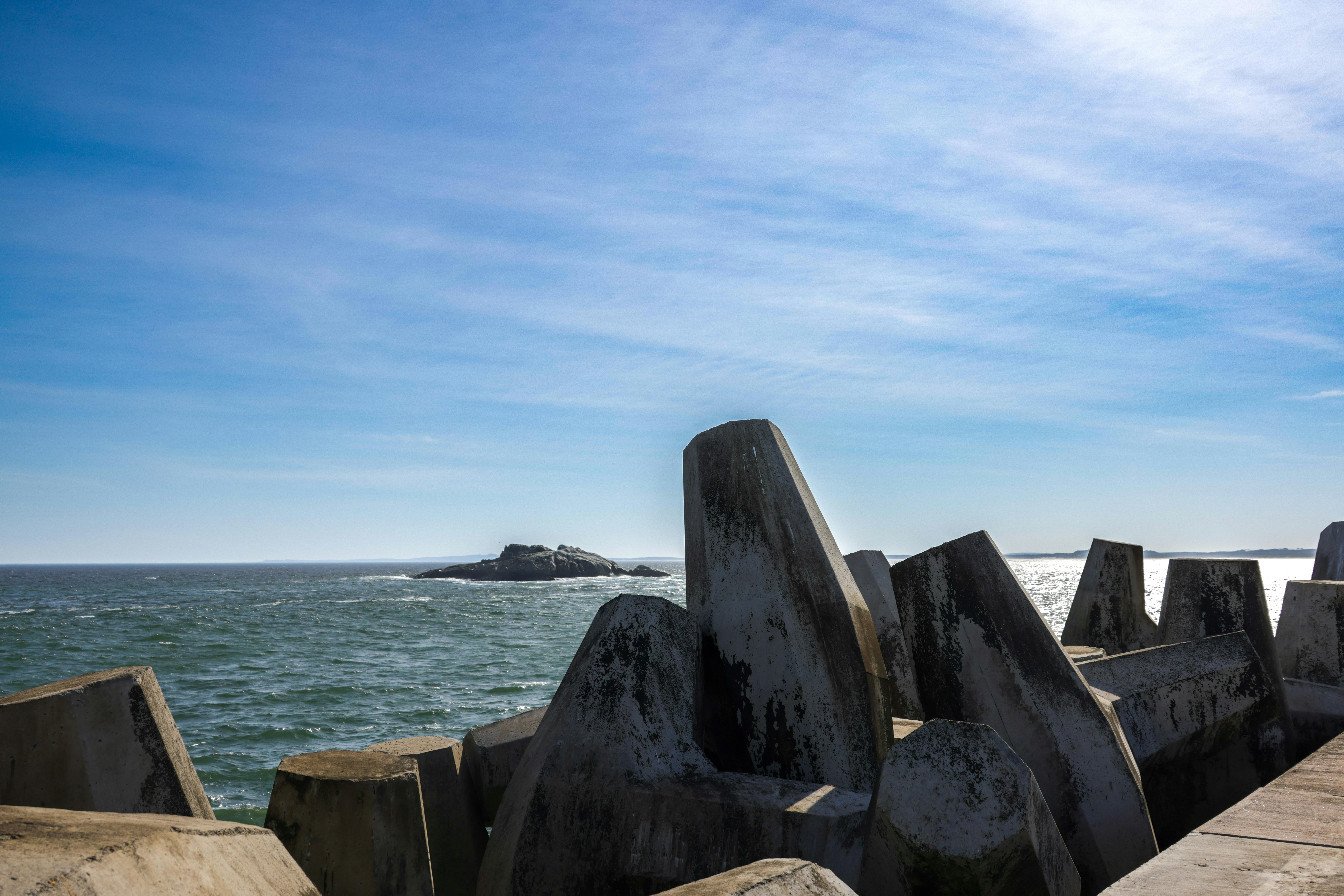 Coastal Breakwater Structures Under Blue Sky · Free Stock Photo