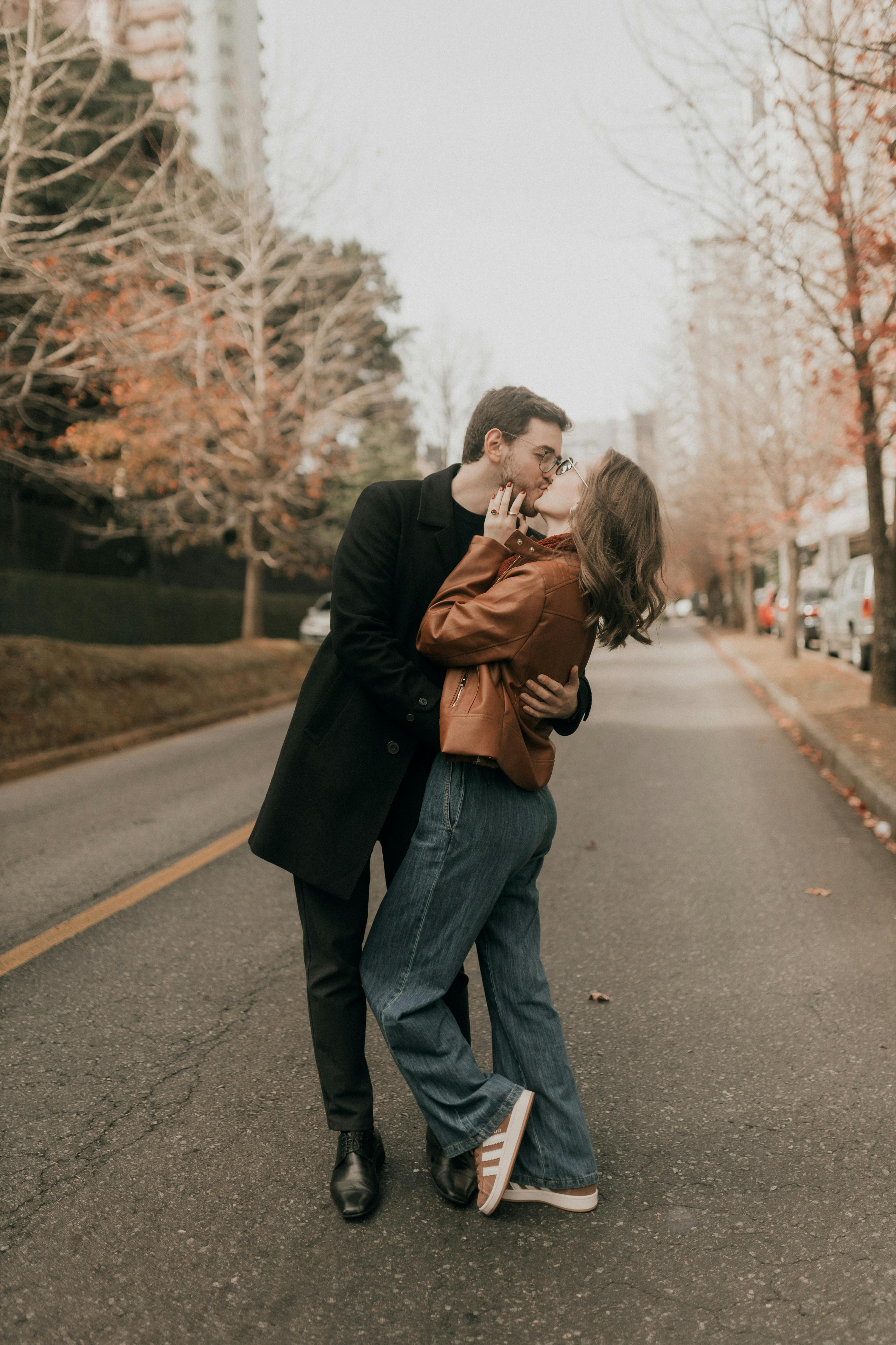 Romantic Couple Kissing in a Tree-Lined Street · Free Stock Photo