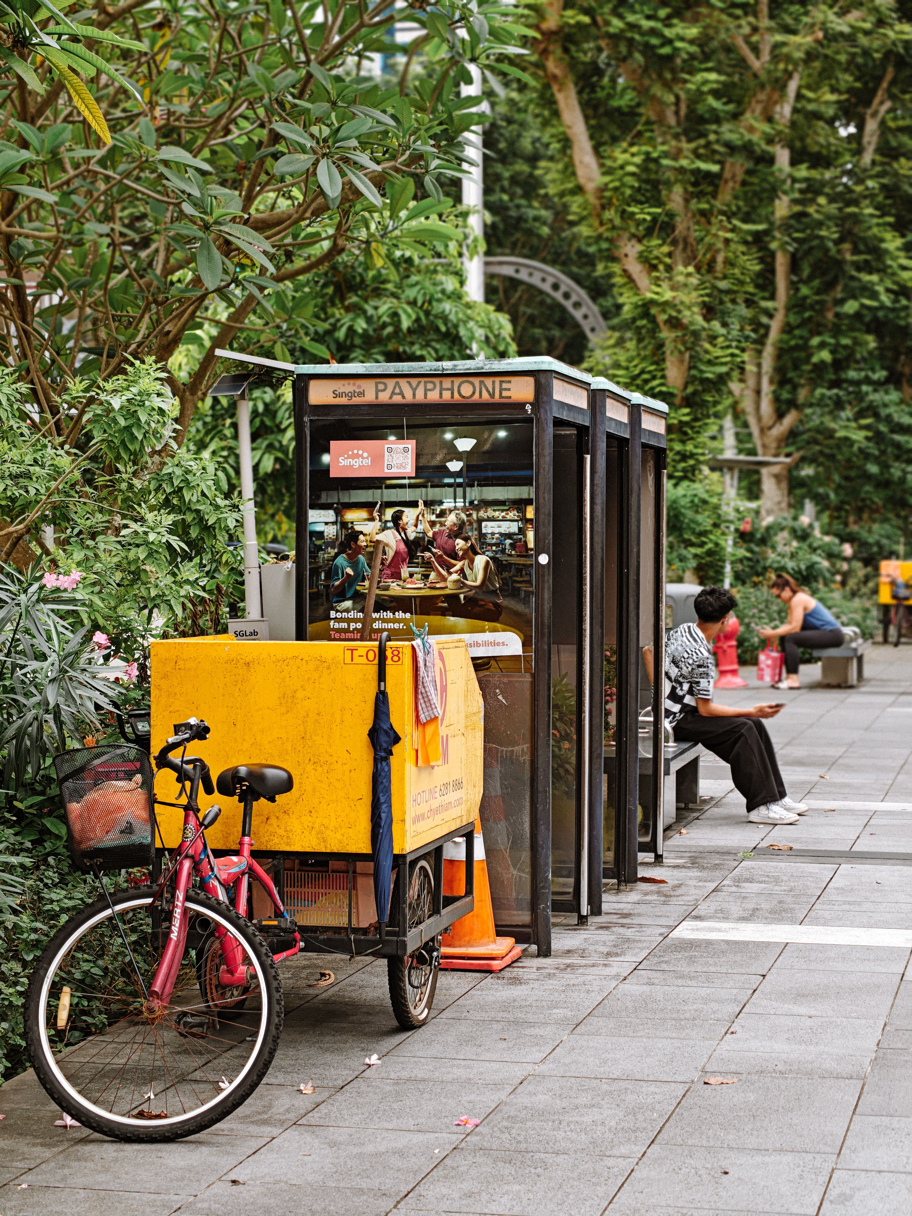 Vintage Payphone Booth in Lush Urban Setting · Free Stock Photo
