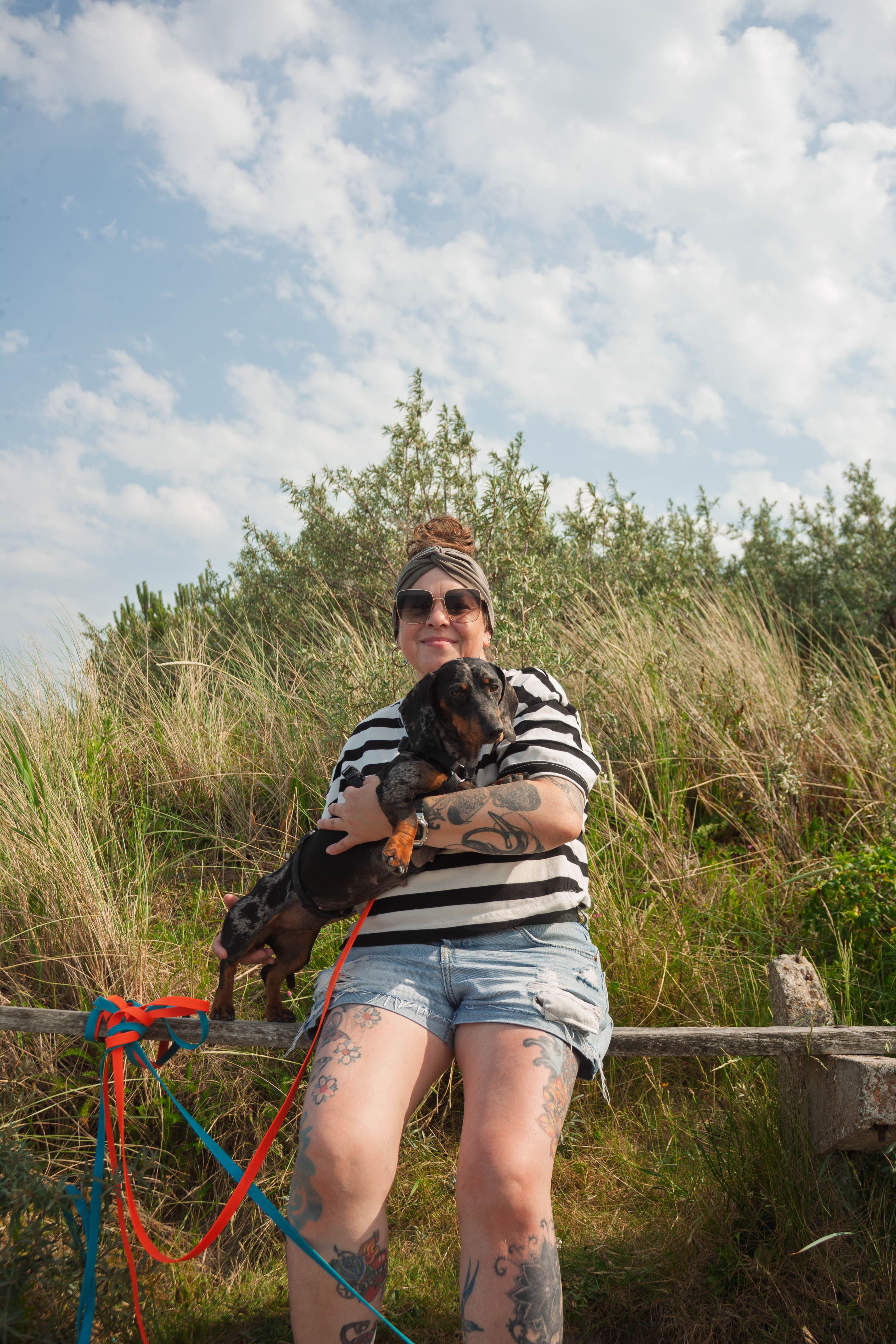 Mujer Con Perro Salchicha En Una Playa Soleada · Foto de stock gratuita