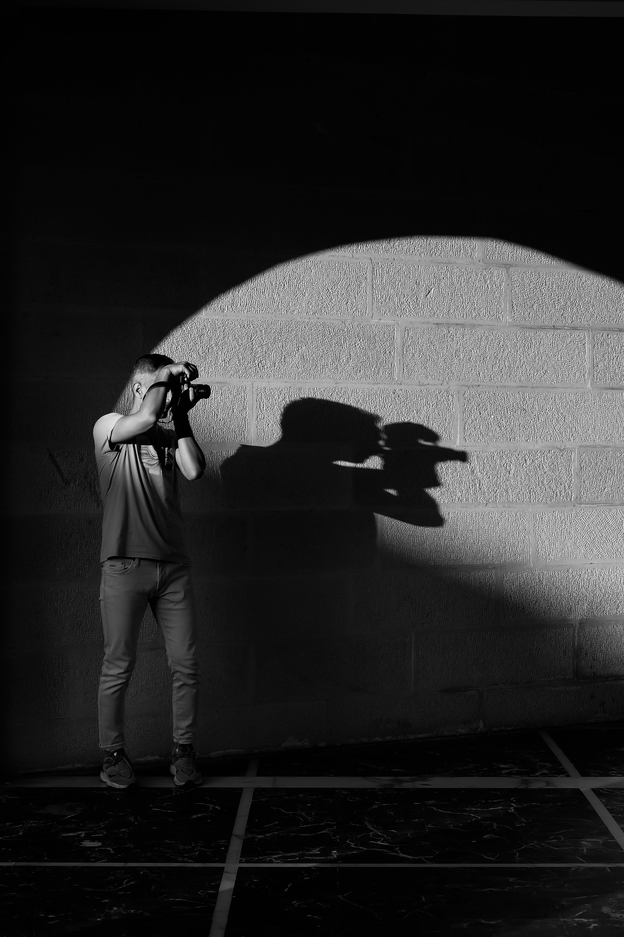 Shadowed Photographer in Dramatic Monochrome Light · Free Stock Photo