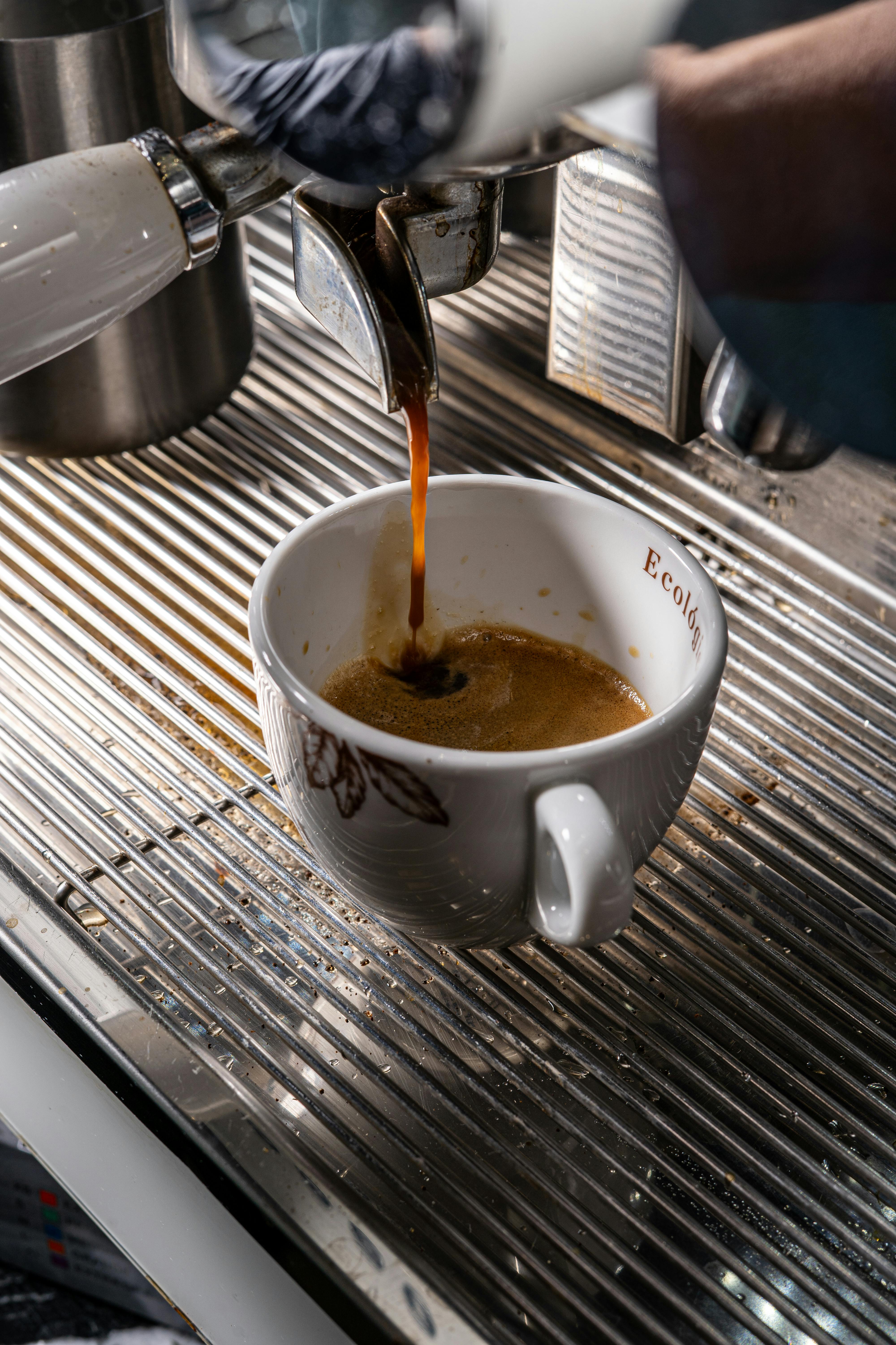 Free Close-up of espresso dripping into a white cup on an espresso ...