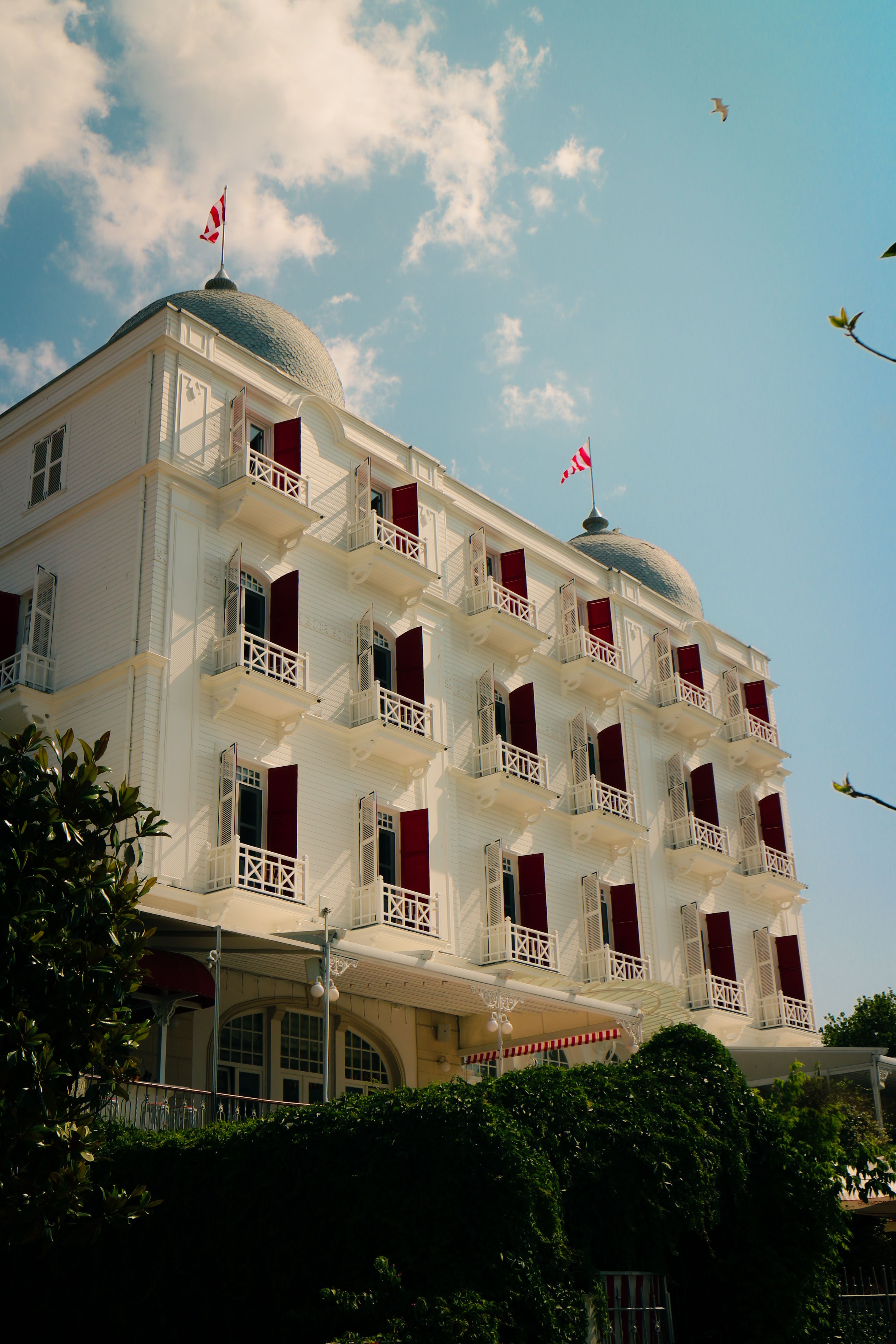 Elegant White Hotel with Red Accents and Flags · Free Stock Photo
