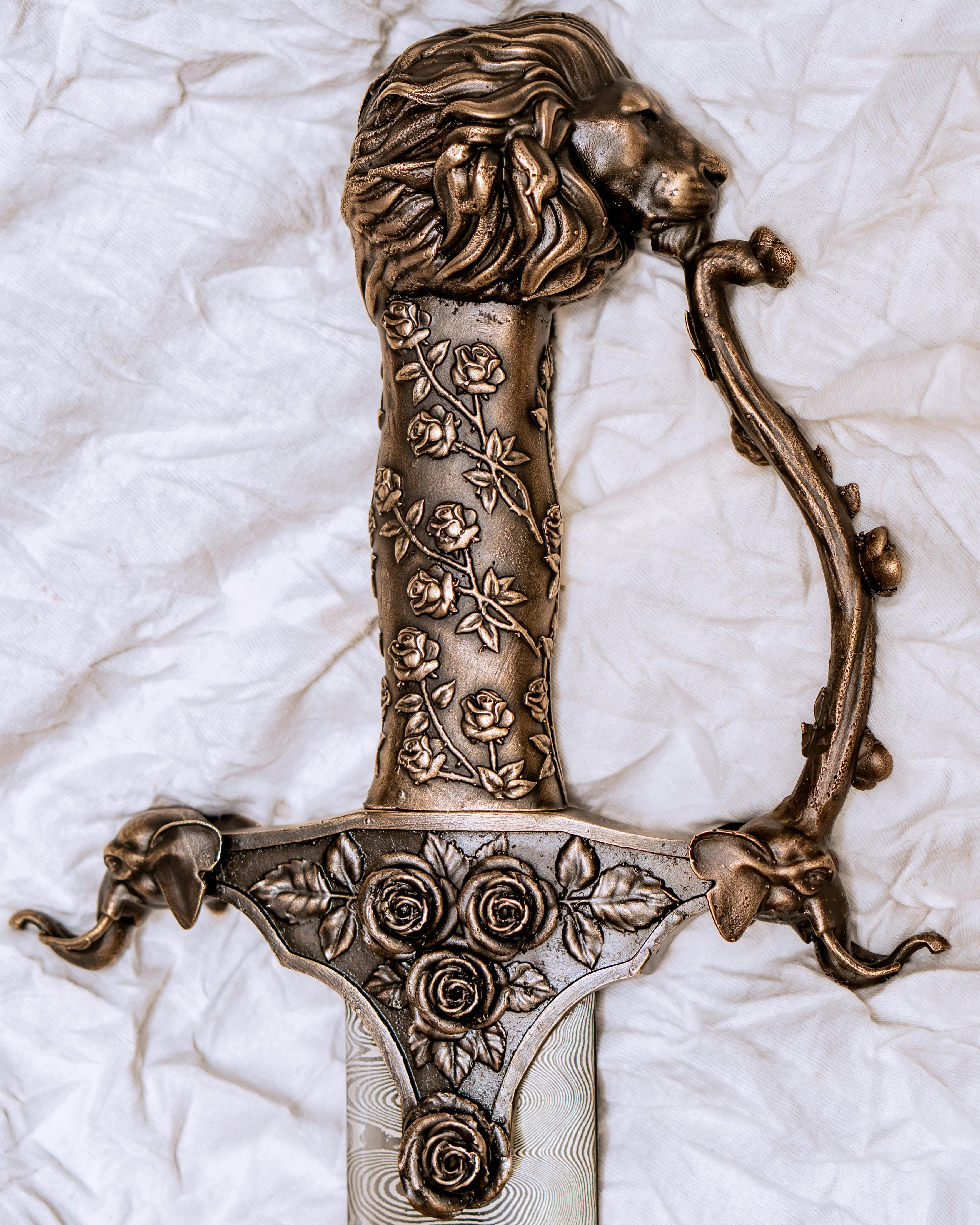 Ornate Bronze Sword Hilt with Lion and Rose Design · Free Stock Photo