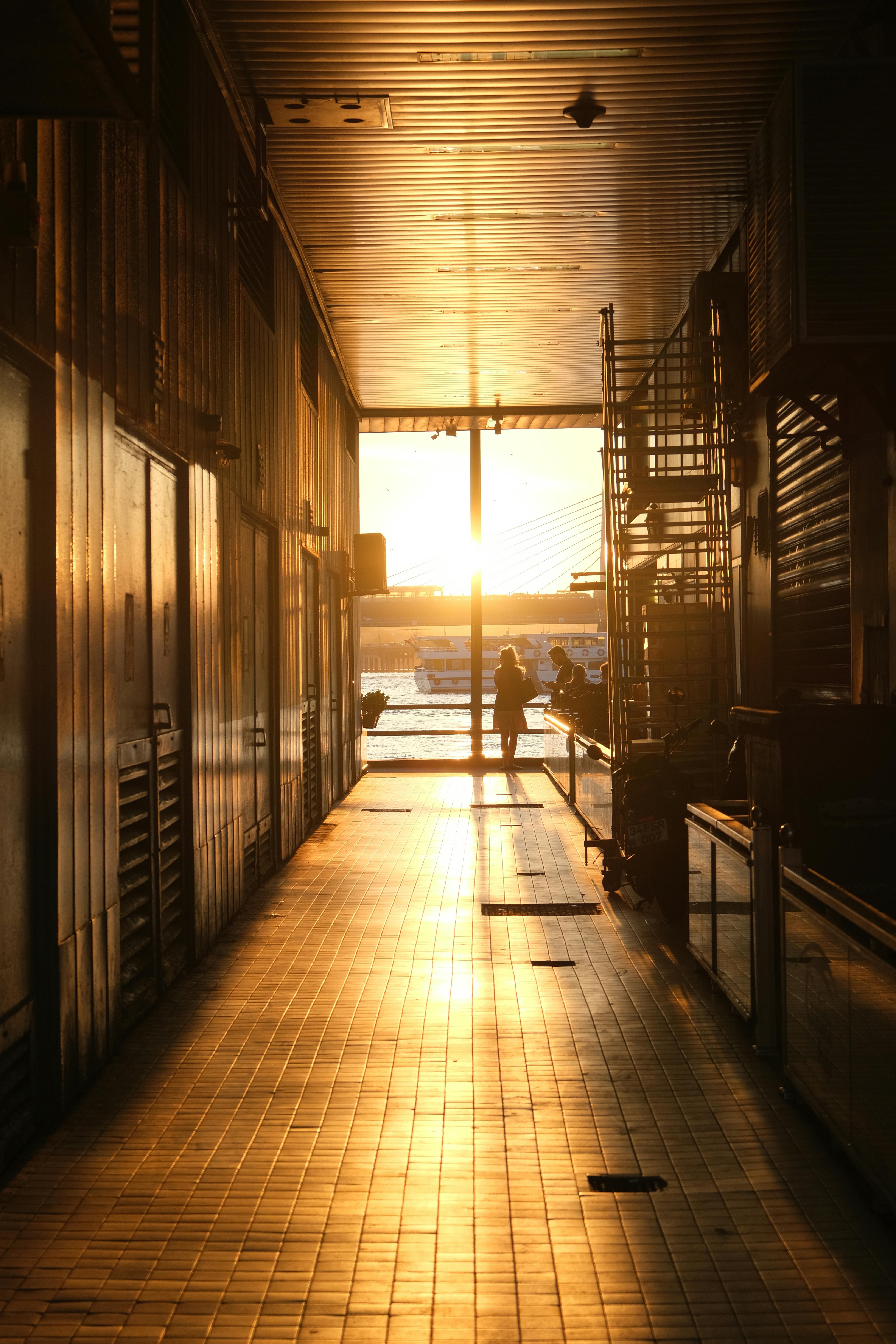 Golden Corridor at Sunset with Silhouetted Figures · Free Stock Photo