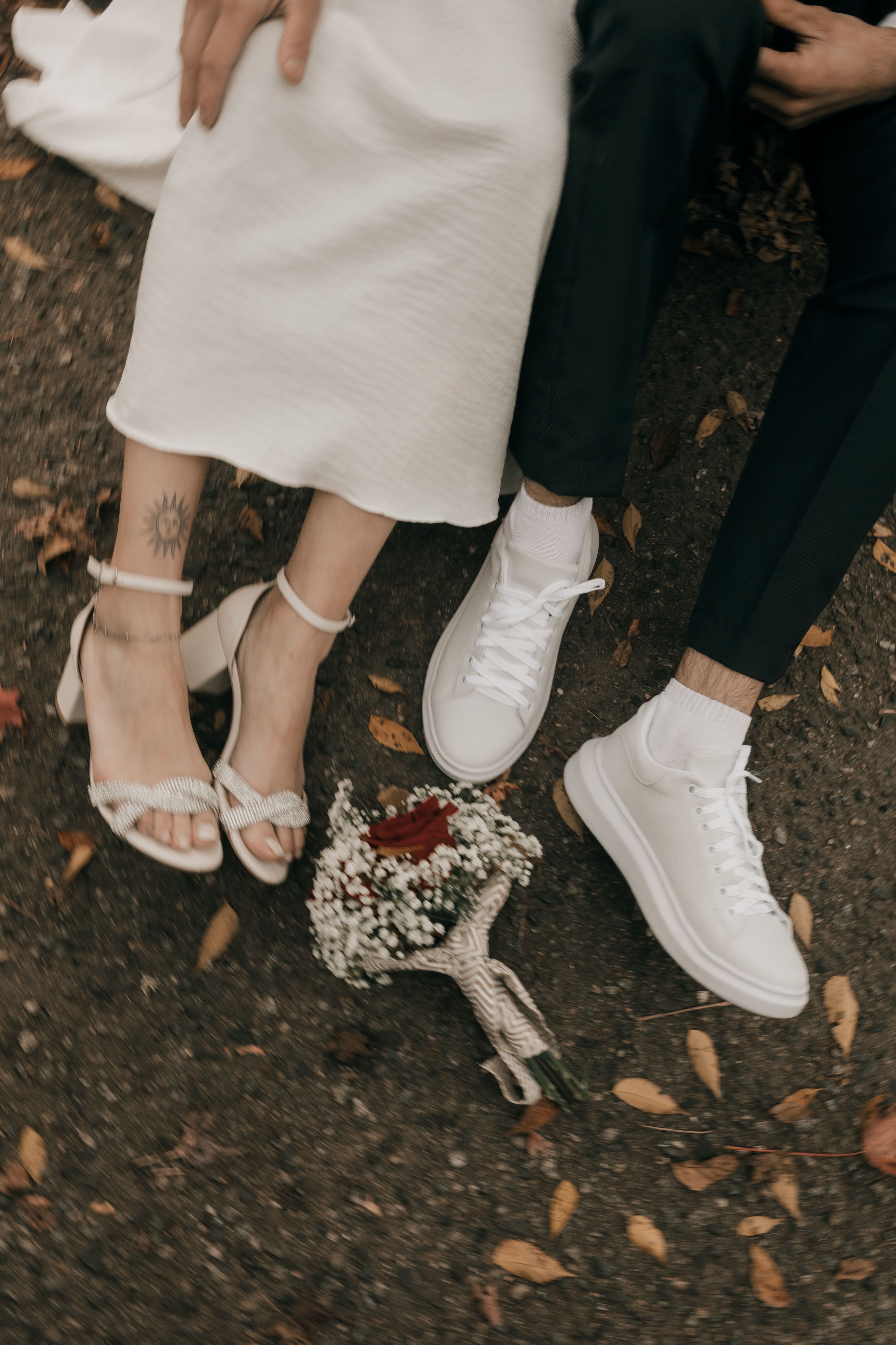 Elegant wedding couple's feet with bouquet · Free Stock Photo