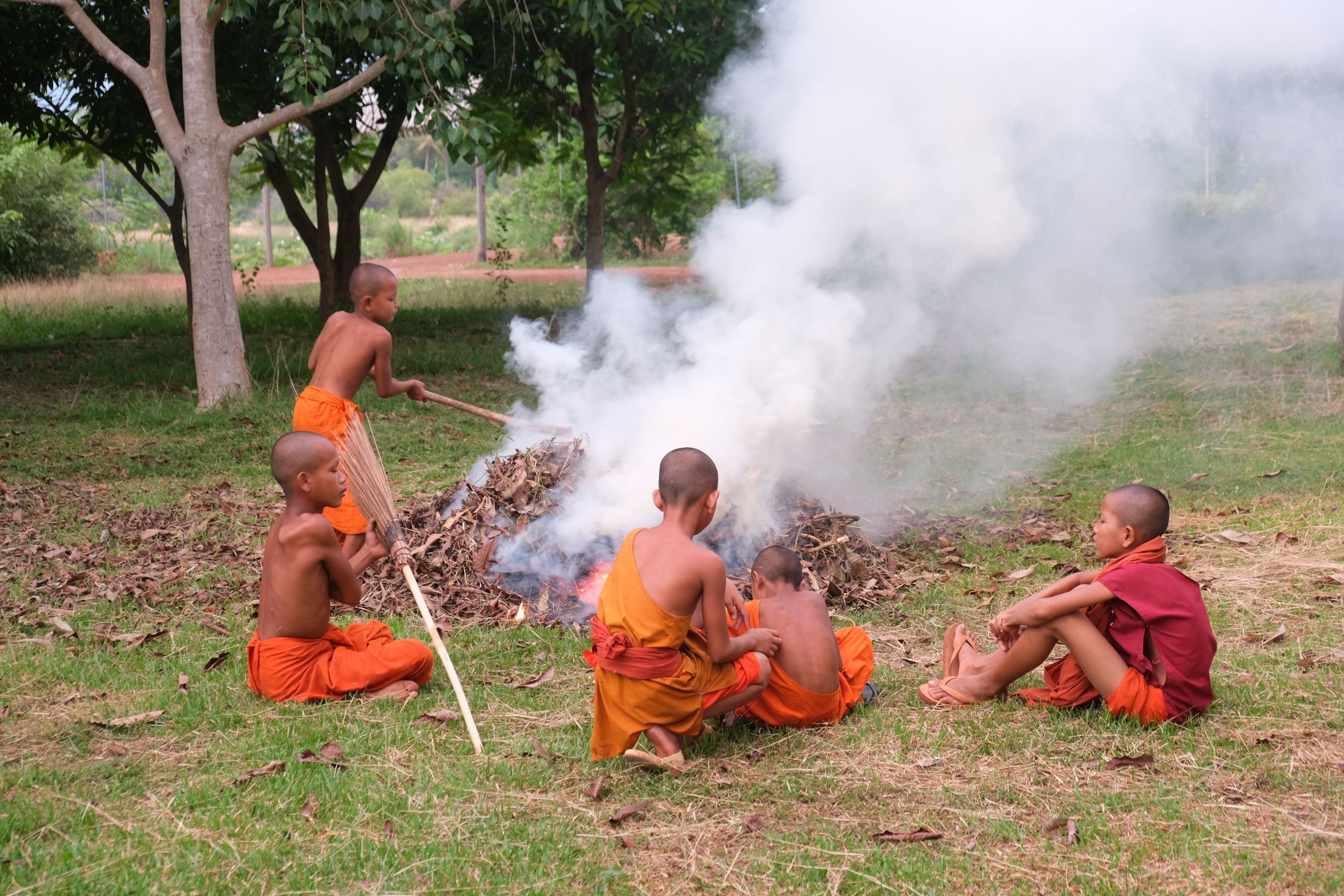 Young Monks Tending a Fire in Cambodian Countryside · Free Stock Photo