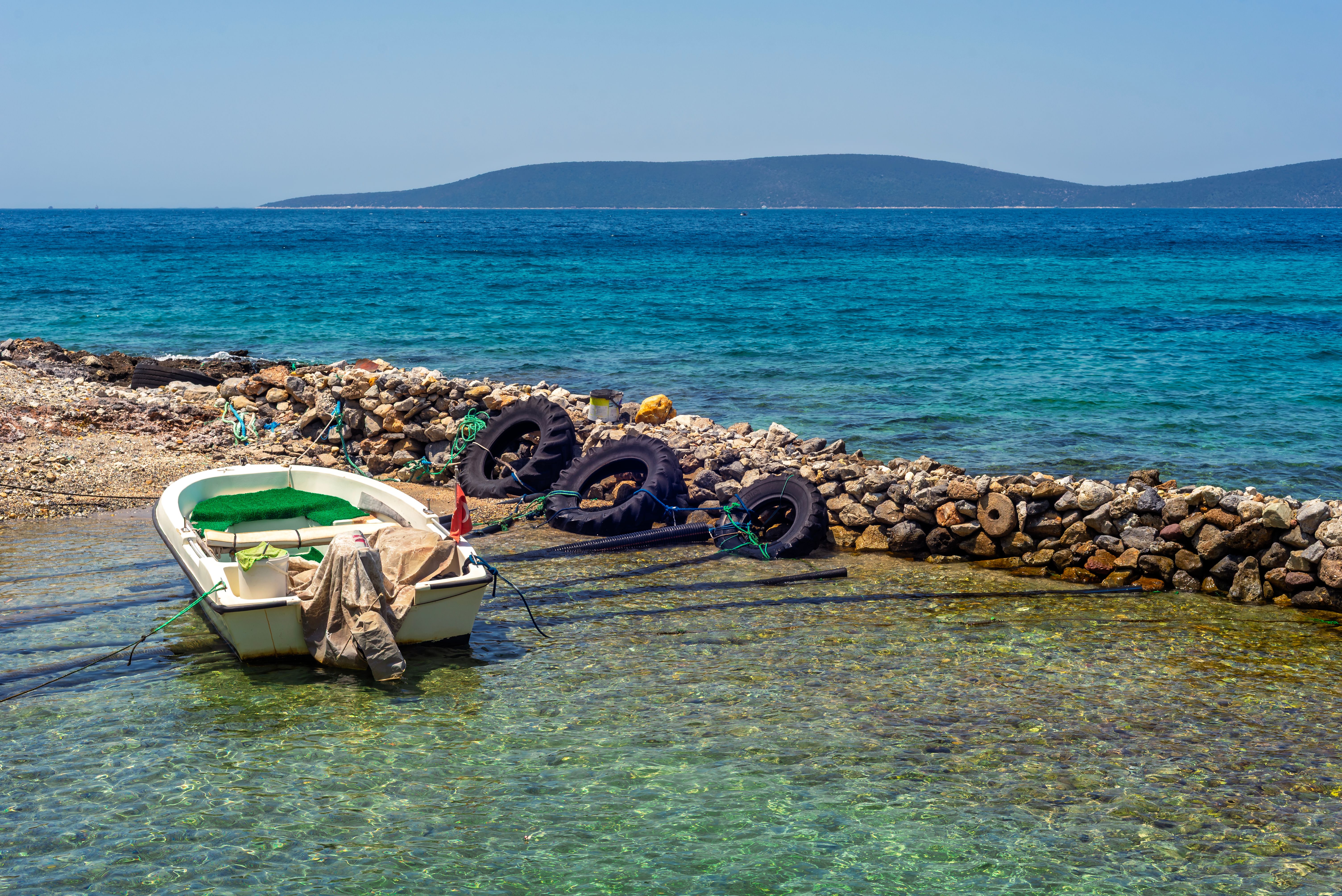 Tranquil Coastal Scene with Small Boat and Stone Pier · Free Stock Photo