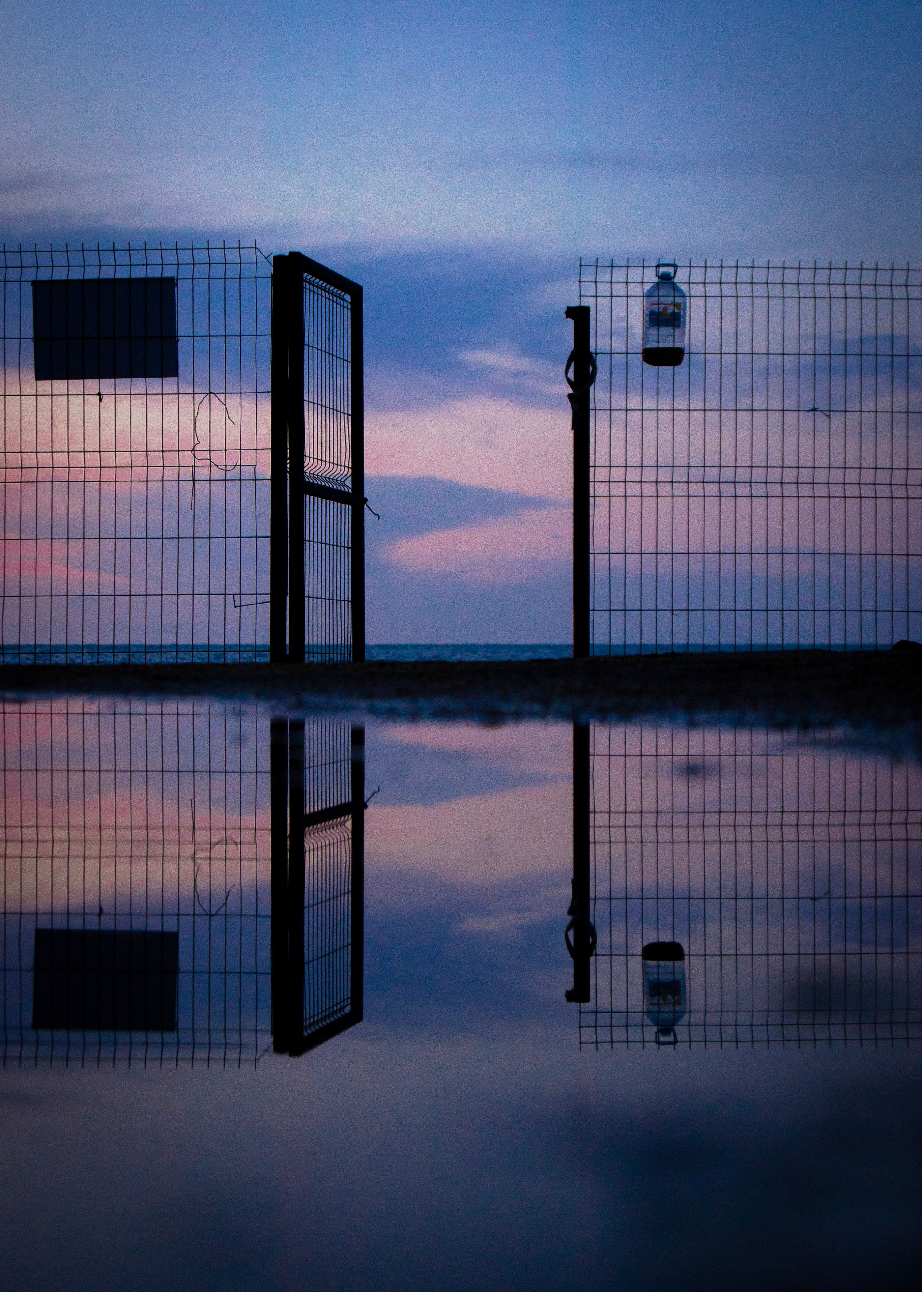 Serene Twilight Reflection by a Fence · Free Stock Photo