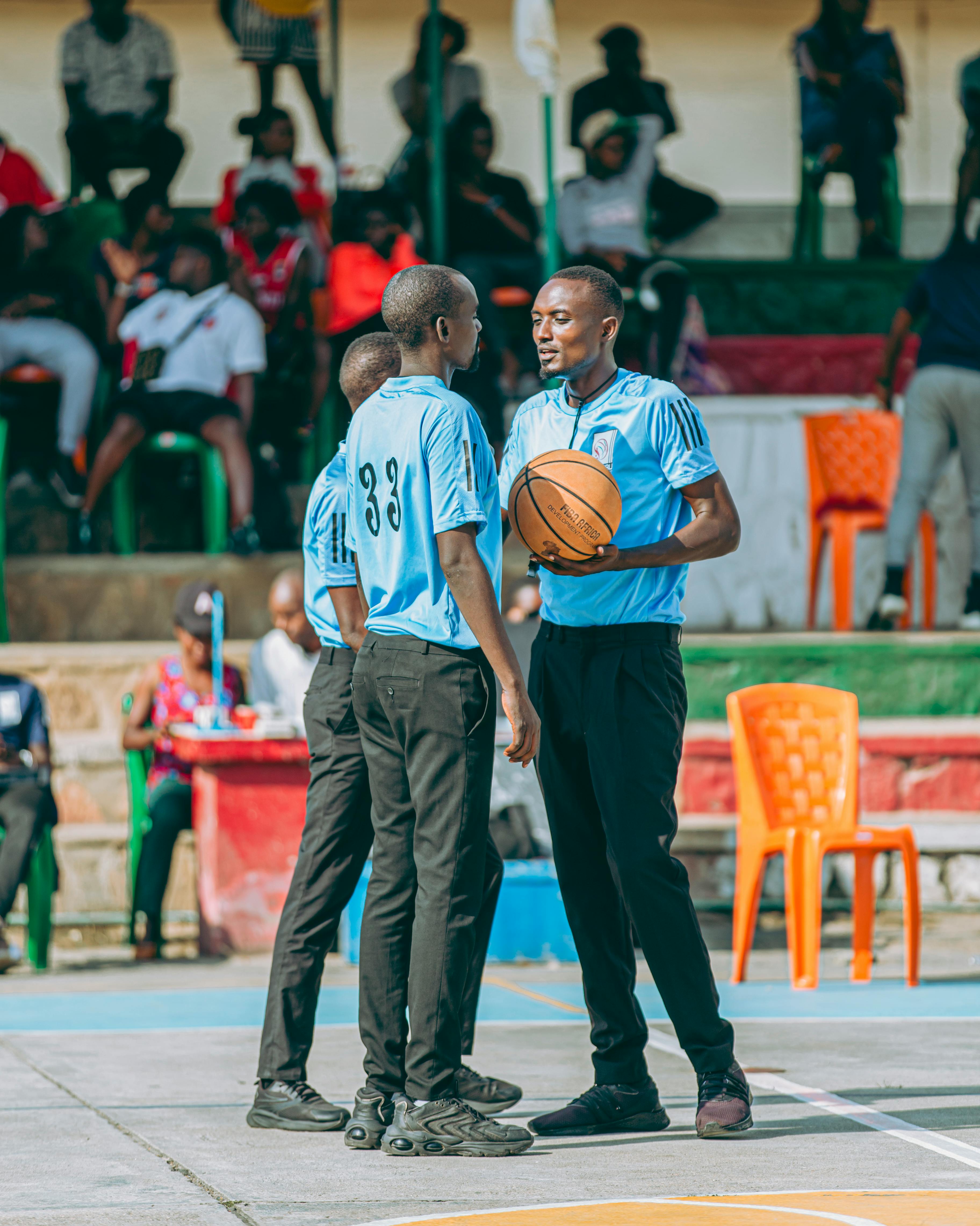 Basketball Referees Discuss Game Strategy Courtside · Free Stock Photo